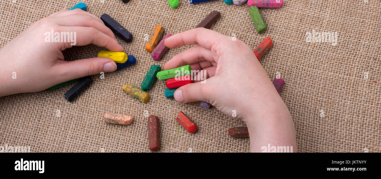 Used color crayons and a hand holding one Stock Photo - Alamy