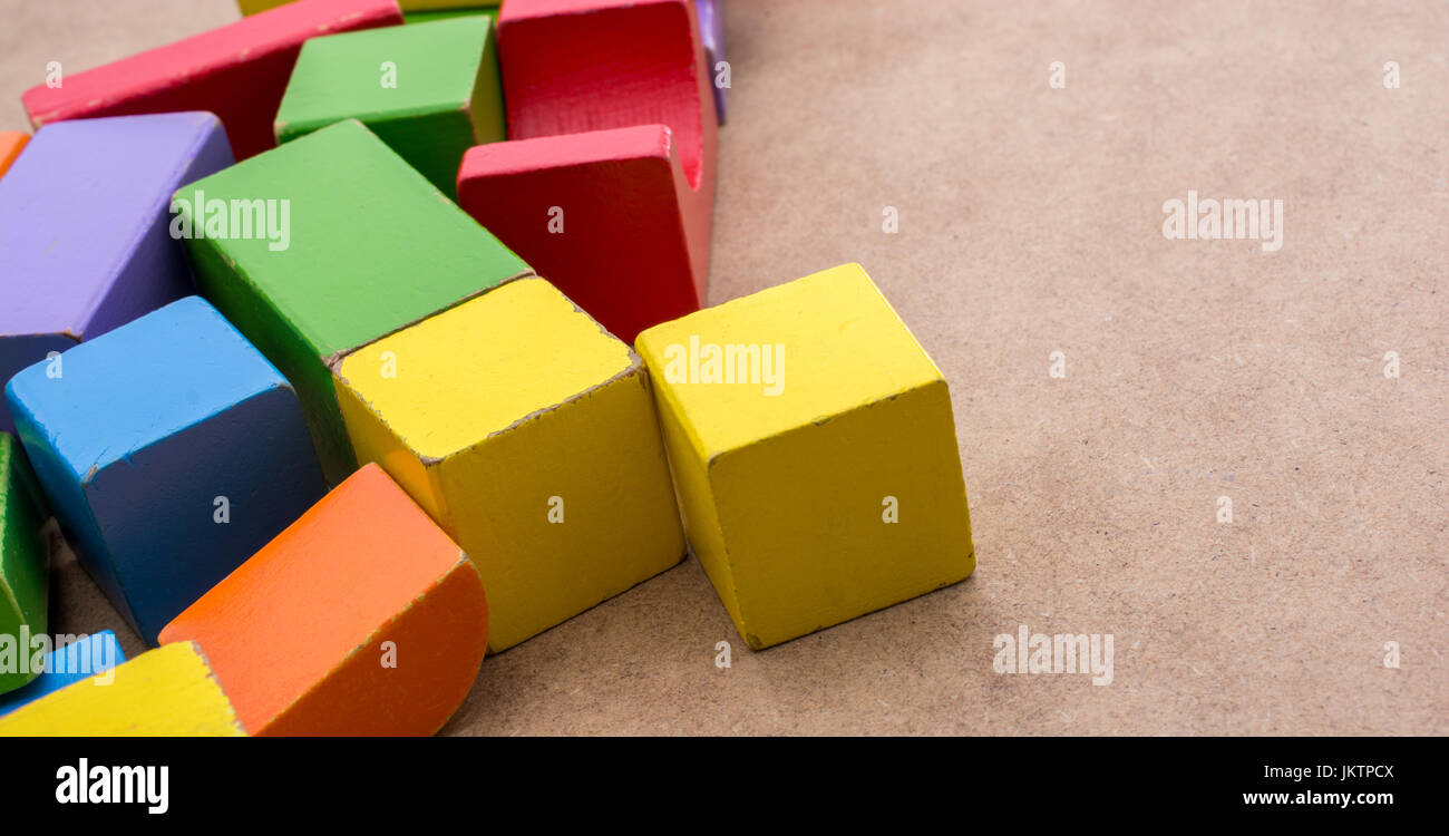 Colorful building blocks on a brown background Stock Photo - Alamy