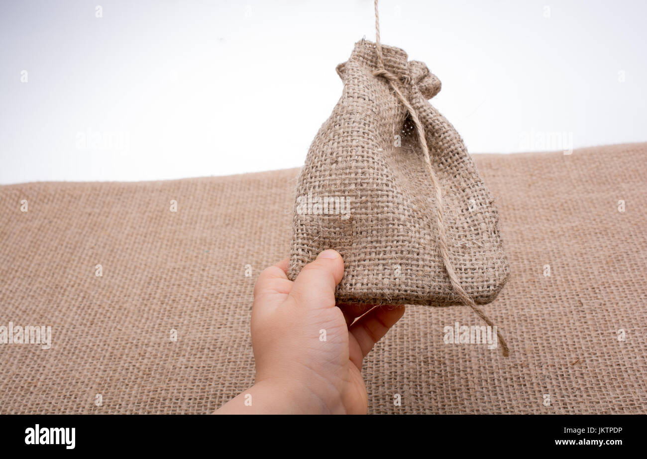 Hand holding an empty little sack made of linen Stock Photo - Alamy