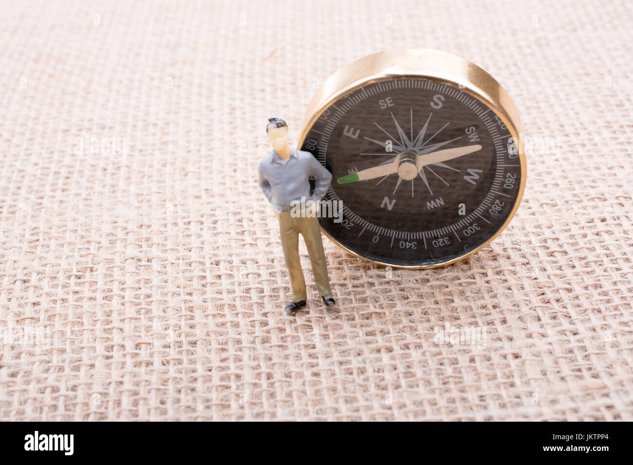 Figurine man beside of a compass on canvas Stock Photo - Alamy