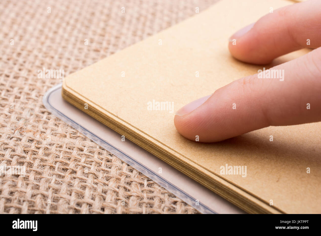 brown color notebook in hand on a canvas background Stock Photo - Alamy