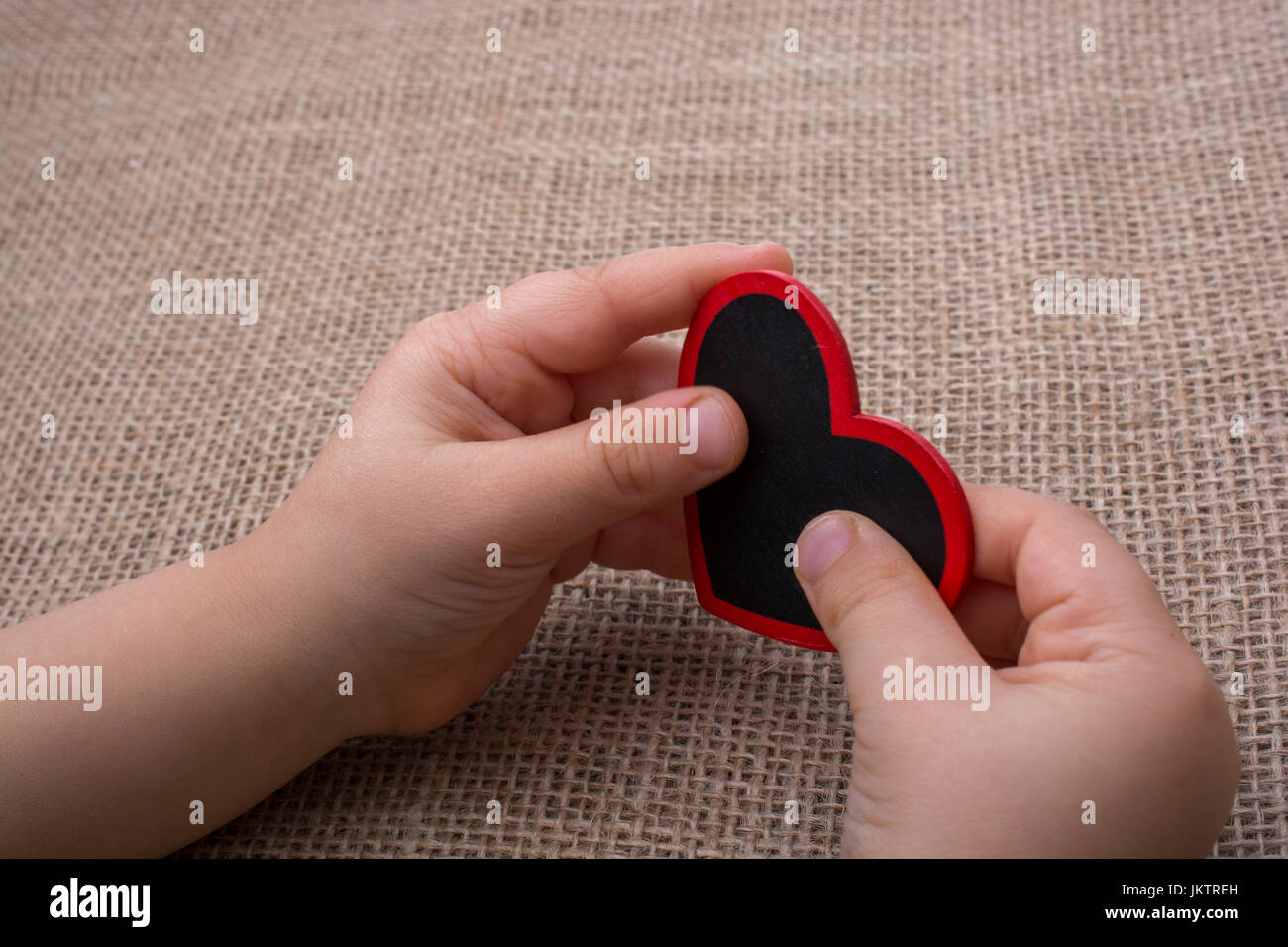 Heart shaped object in hand on canvas Stock Photo - Alamy