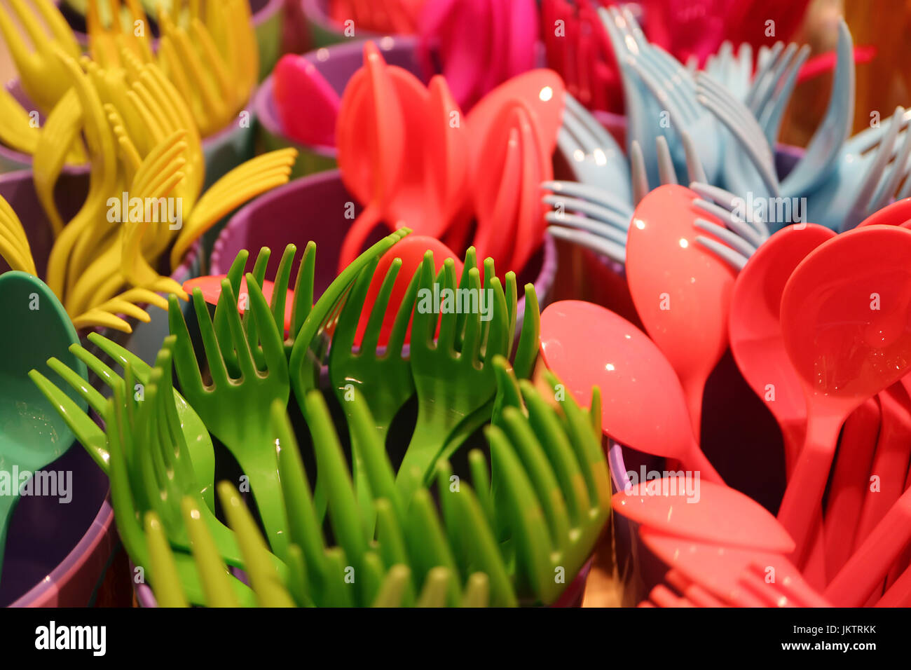 Closed up bunch of multi-color plastic ware cutlery with selective ...
