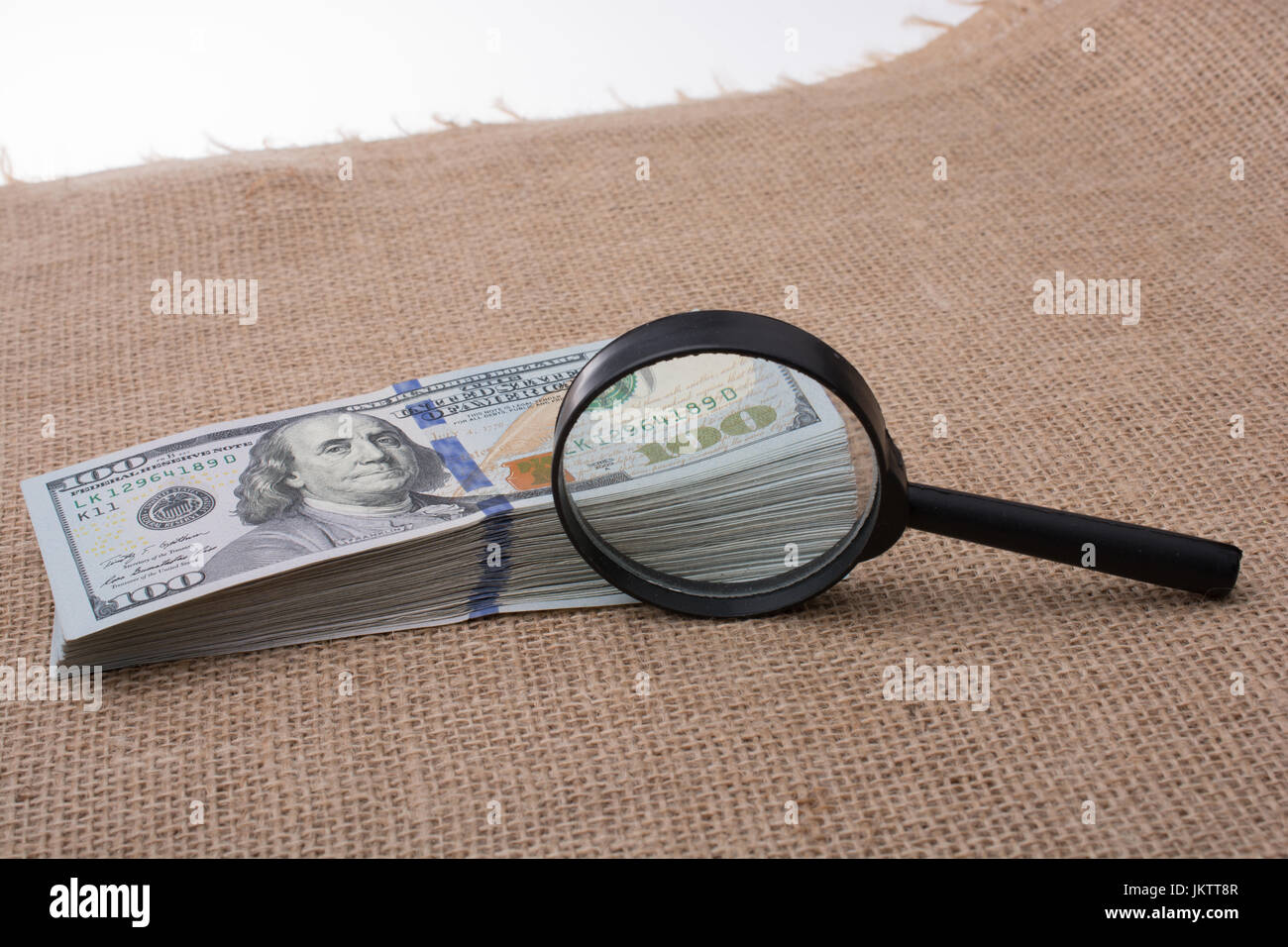 Magnifying glass over the banknote bundle of US dollar Stock Photo - Alamy