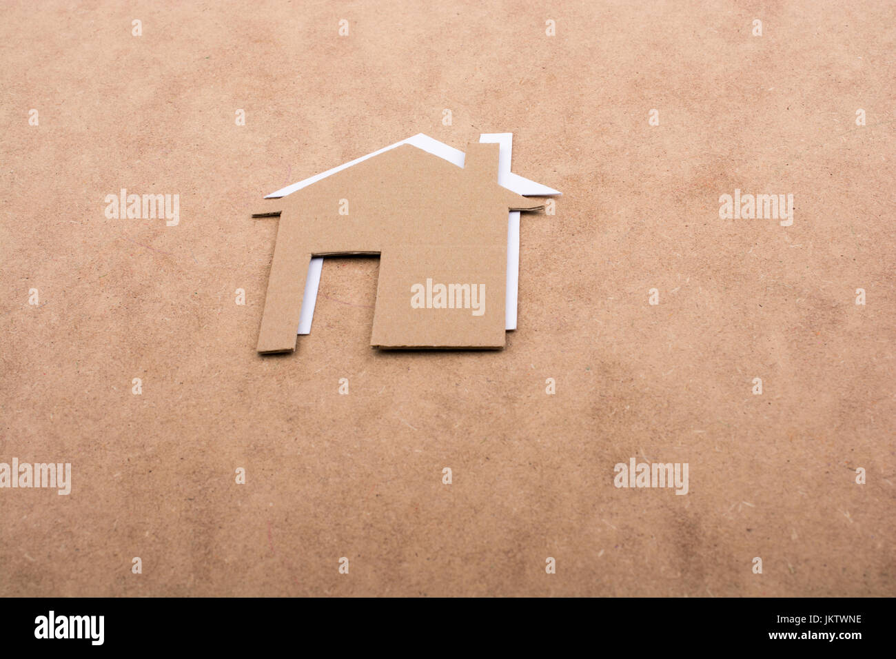 Little paper houses on a brown background Stock Photo - Alamy