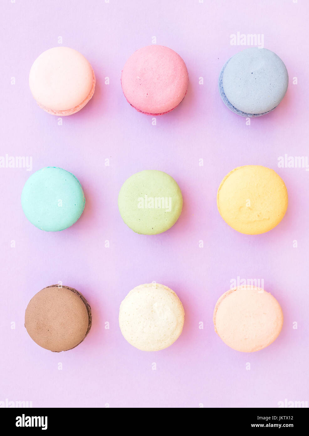 Sweet colorful French macaroon biscuits on pastel lilac background ...