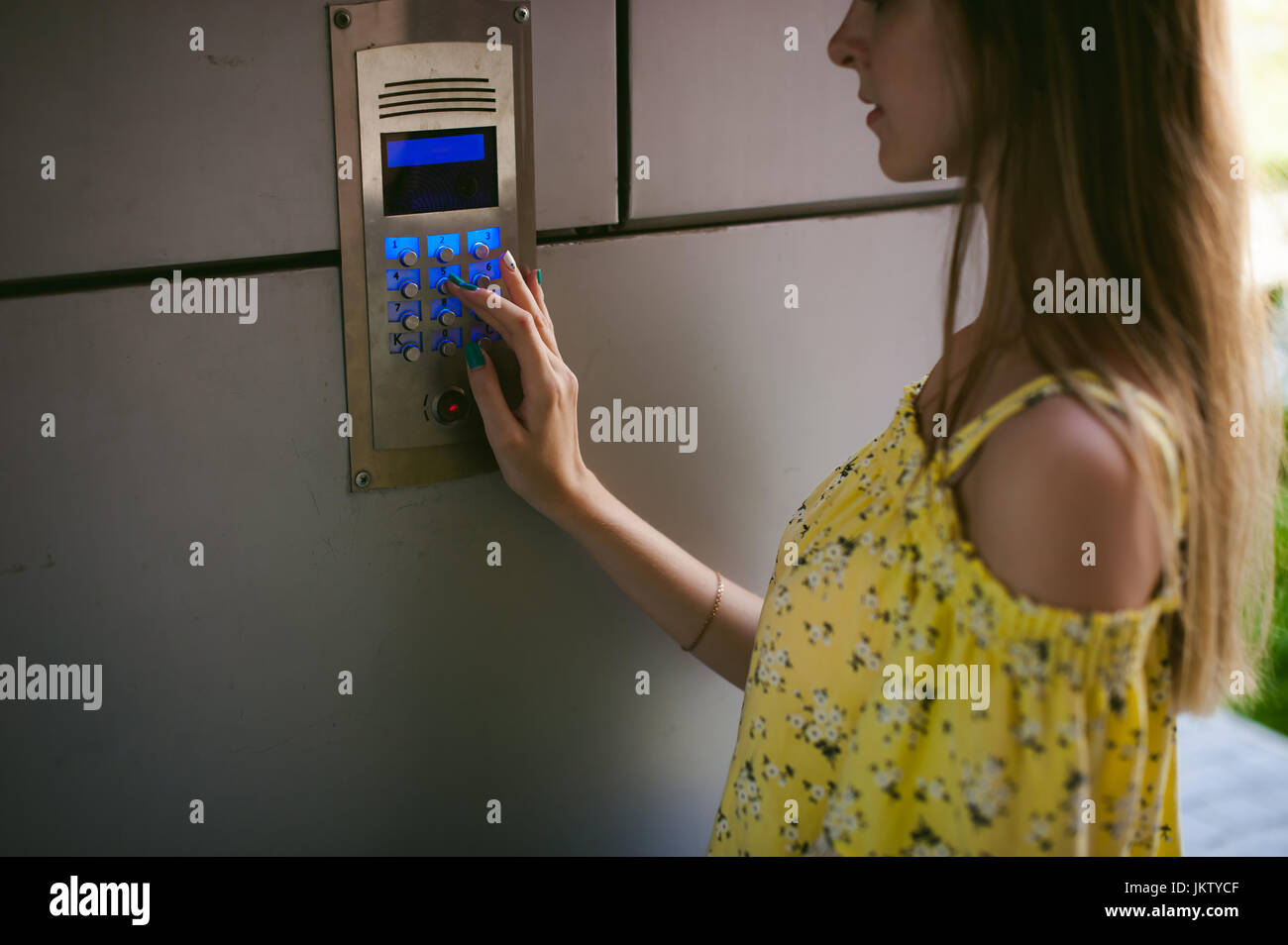 woman dials an apartment code on an electronic doorphone panel Stock ...