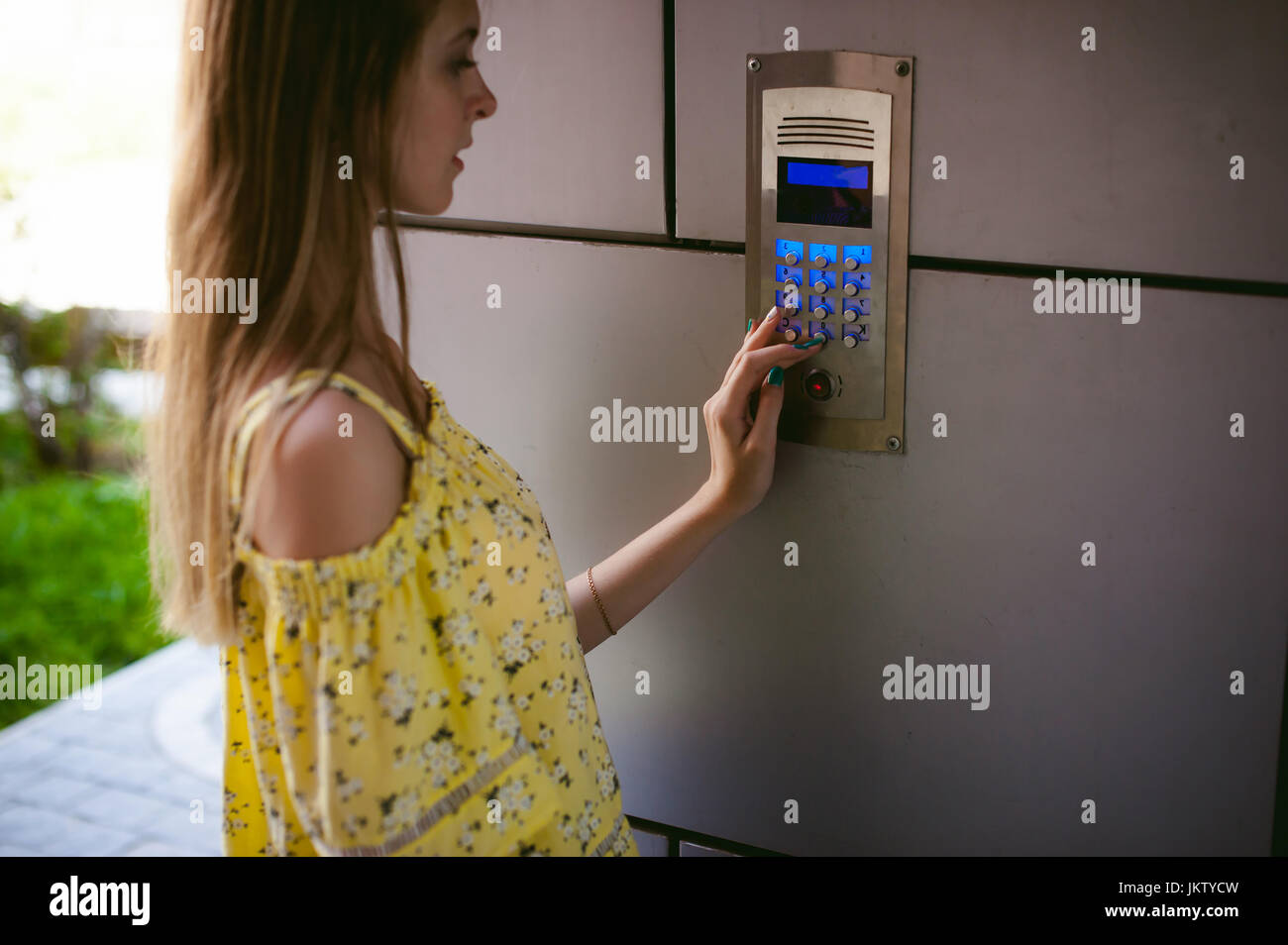woman dials an apartment code on an electronic doorphone panel Stock ...