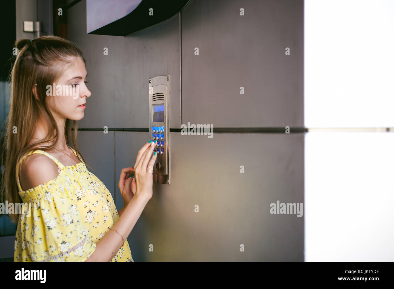 woman dials an apartment code on an electronic doorphone panel Stock ...