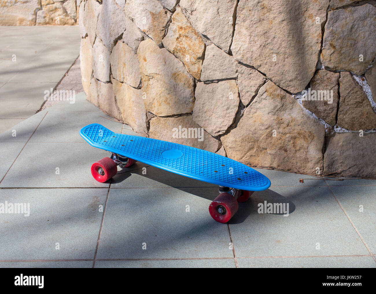 Blue longboard near the stone wall Stock Photo - Alamy