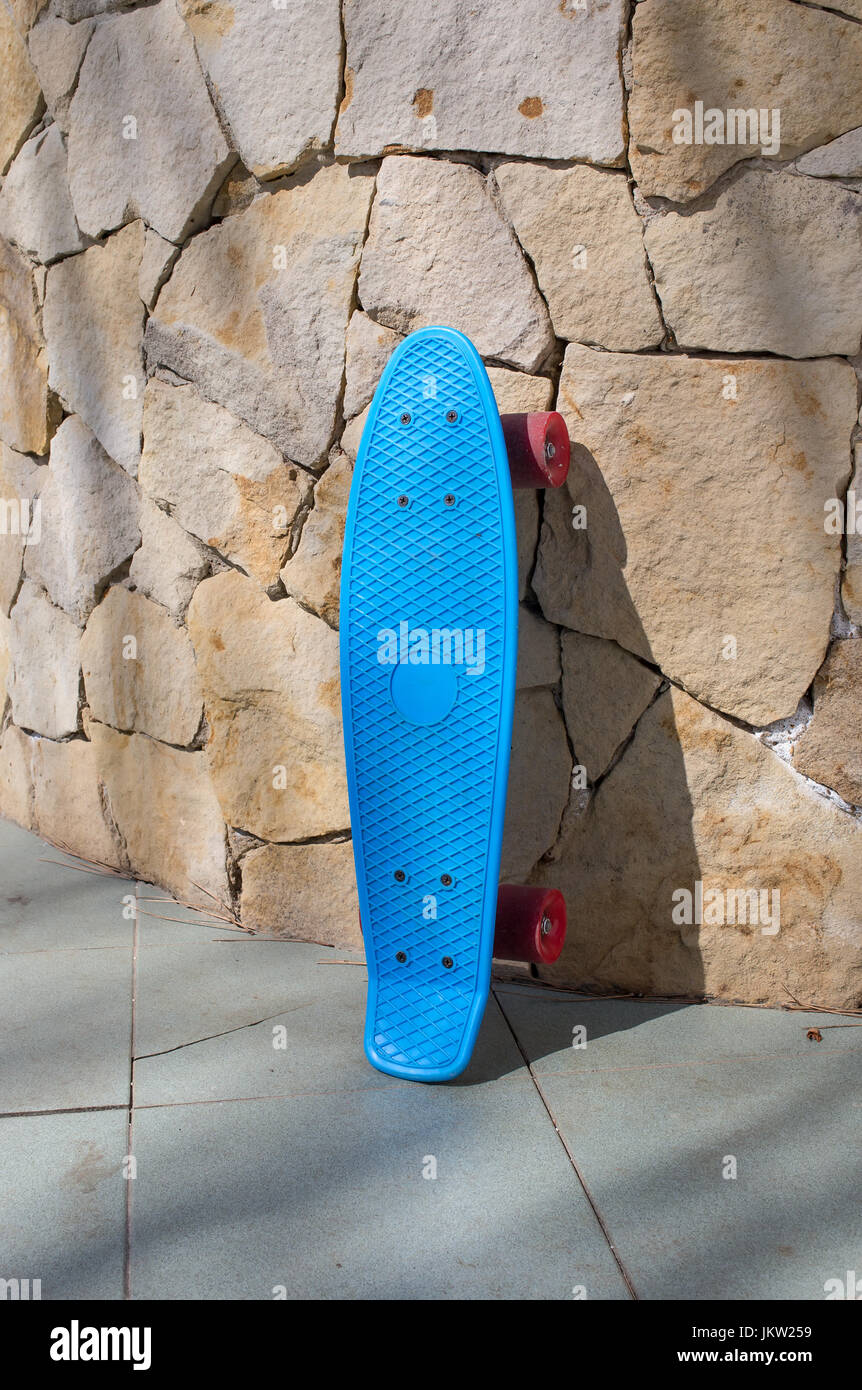 Blue longboard near the stone wall Stock Photo - Alamy