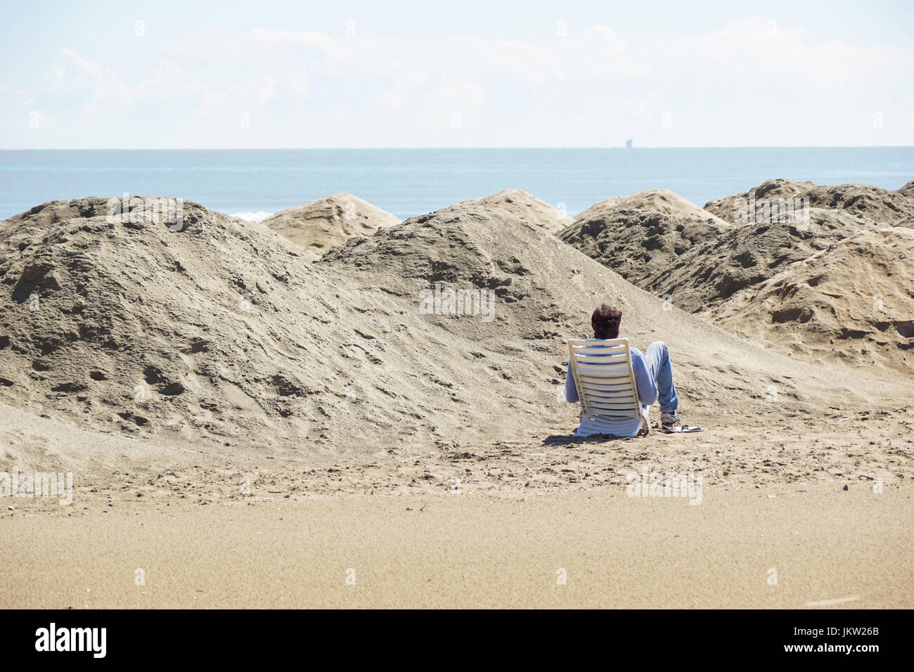 back view of a young man reading a book on the beach Stock Photo - Alamy