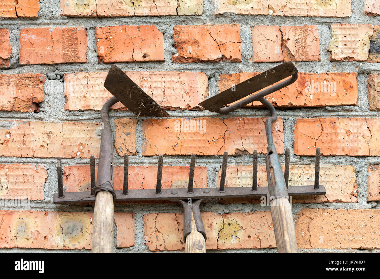 Still life of old / rusty, rake and hoe garden tools against the old ...