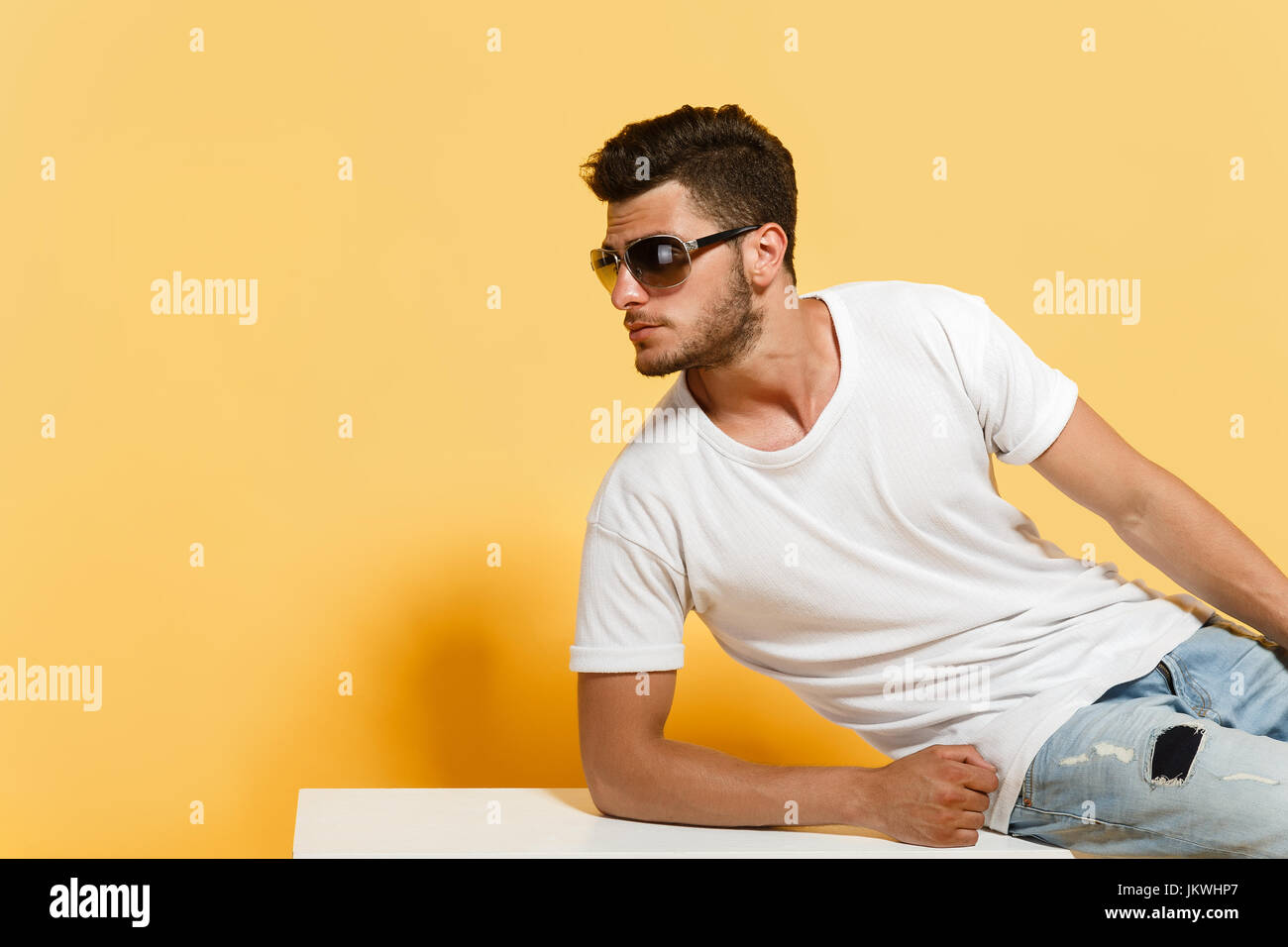 Good-looking man leaning upon white surface Stock Photo - Alamy