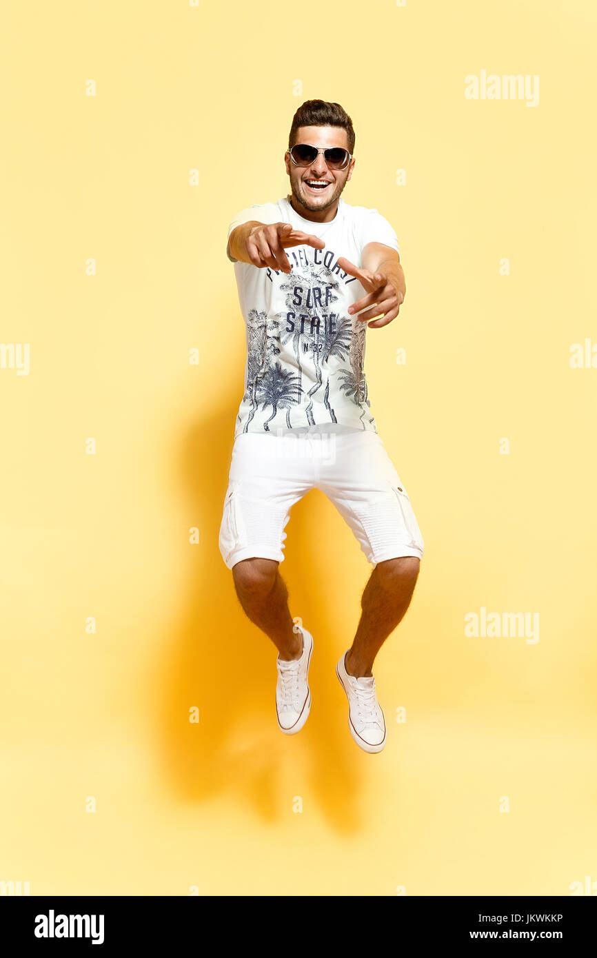 Handsome guy jumping looking at camera Stock Photo - Alamy