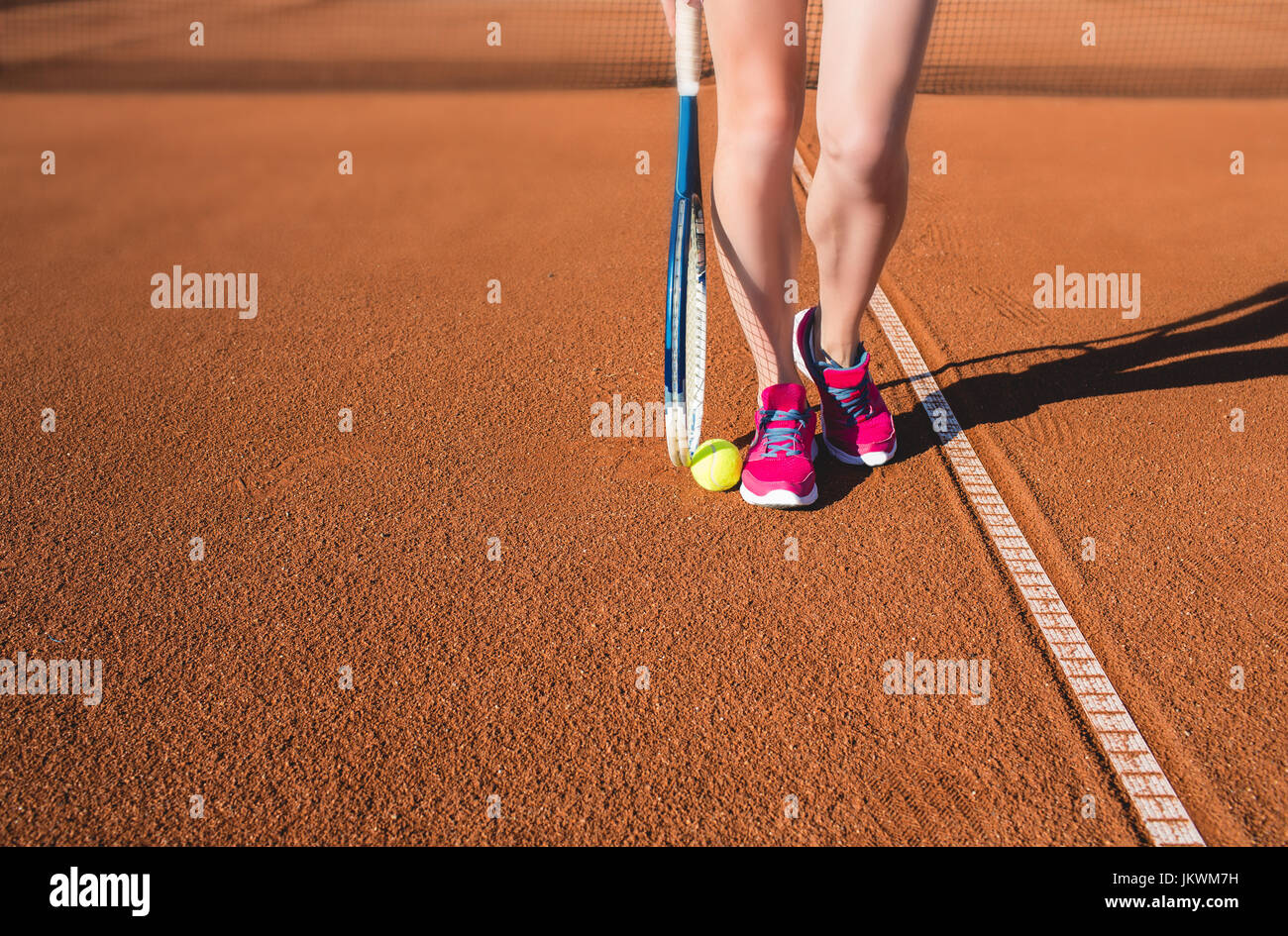 Closeup photo of female legs with tennis racket Stock Photo - Alamy