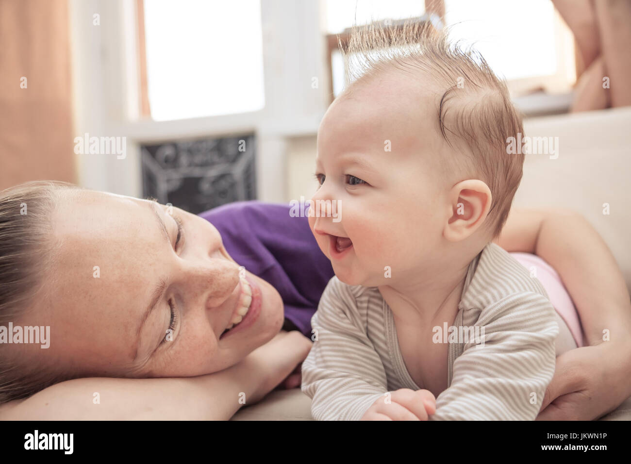 Happy mother looking and embracing her smiling baby symbolize happiness ...