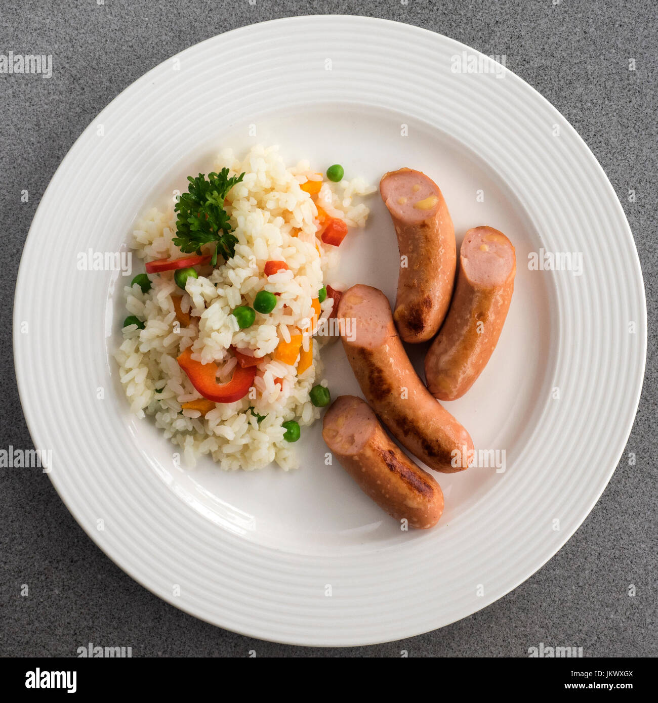 Sausages with boiled rice with vegetables Stock Photo - Alamy