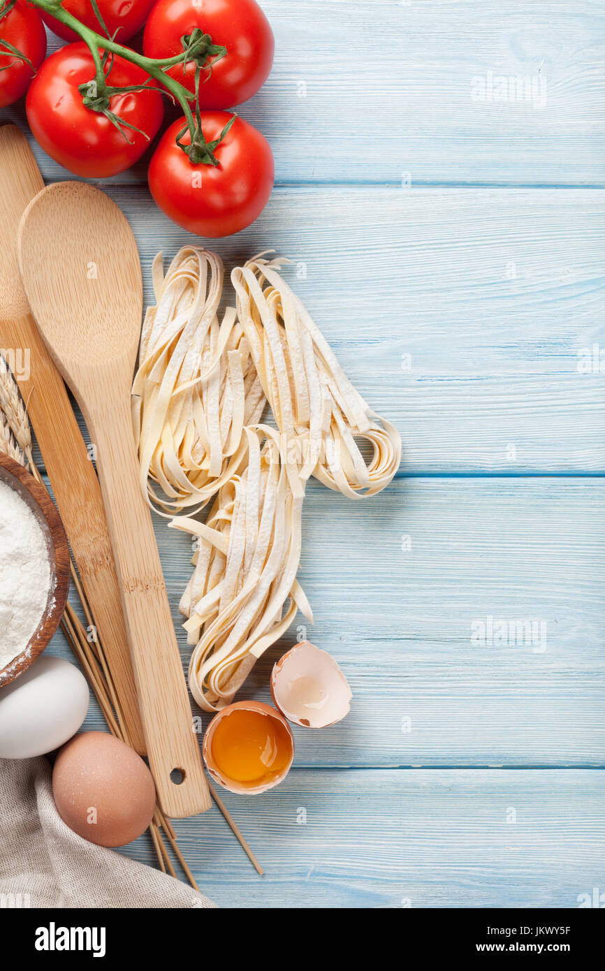 Pasta cooking ingredients on wooden kitchen table. Top view with space ...