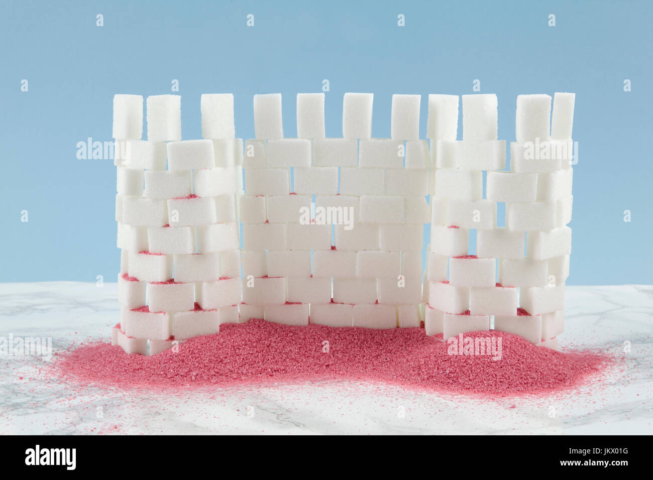 A castle built with sugar cube and pink sand at its feet. Minimal and ...