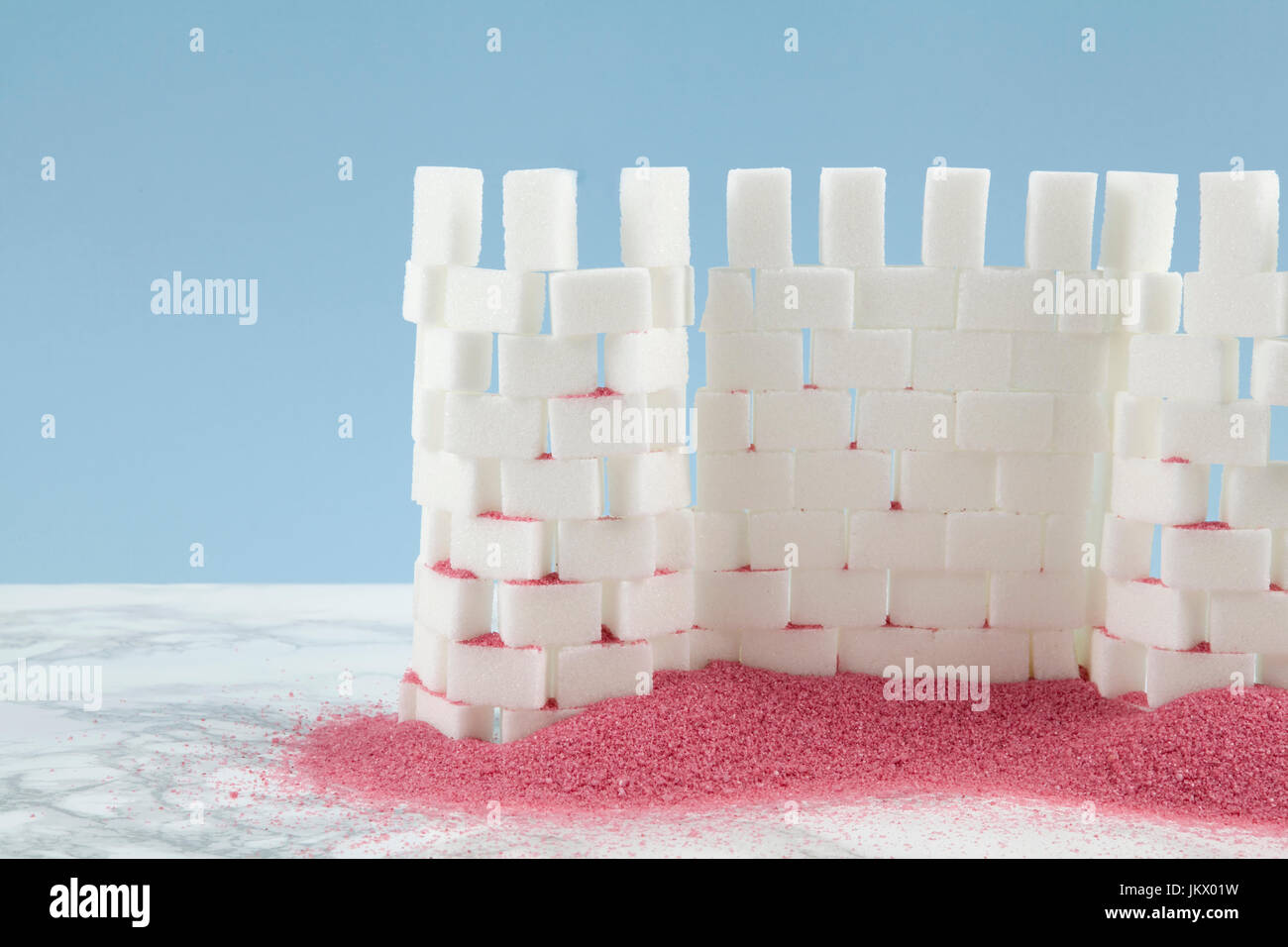 A castle built with sugar cube and pink sand at its feet. Minimal and ...