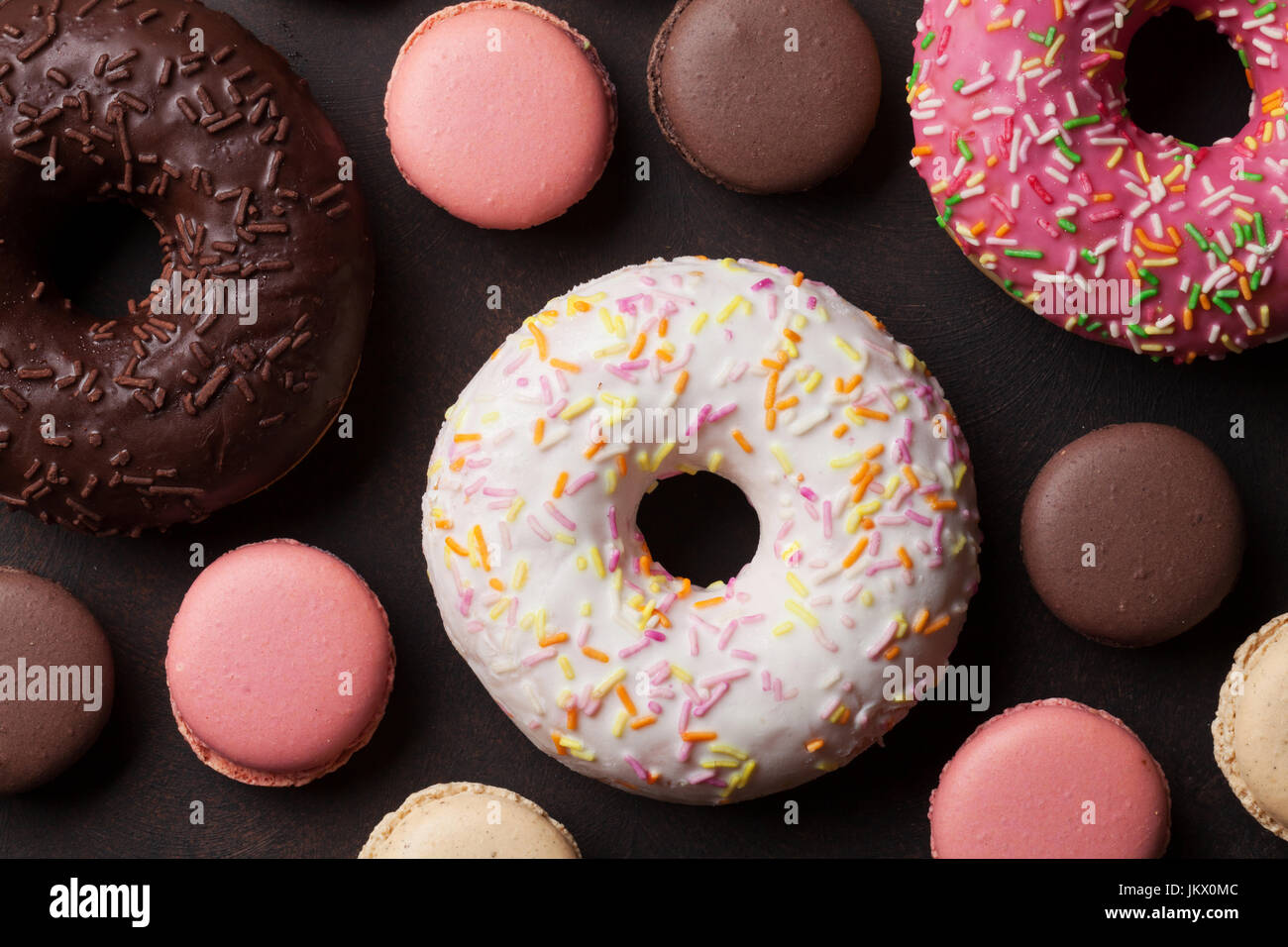Colorful donuts and macaroons on stone table. Top view Stock Photo - Alamy