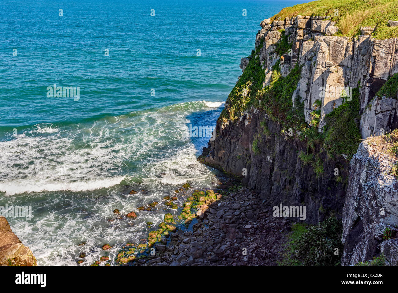 Stone wall ending in the sea where it meets the sea and the waves Stock ...