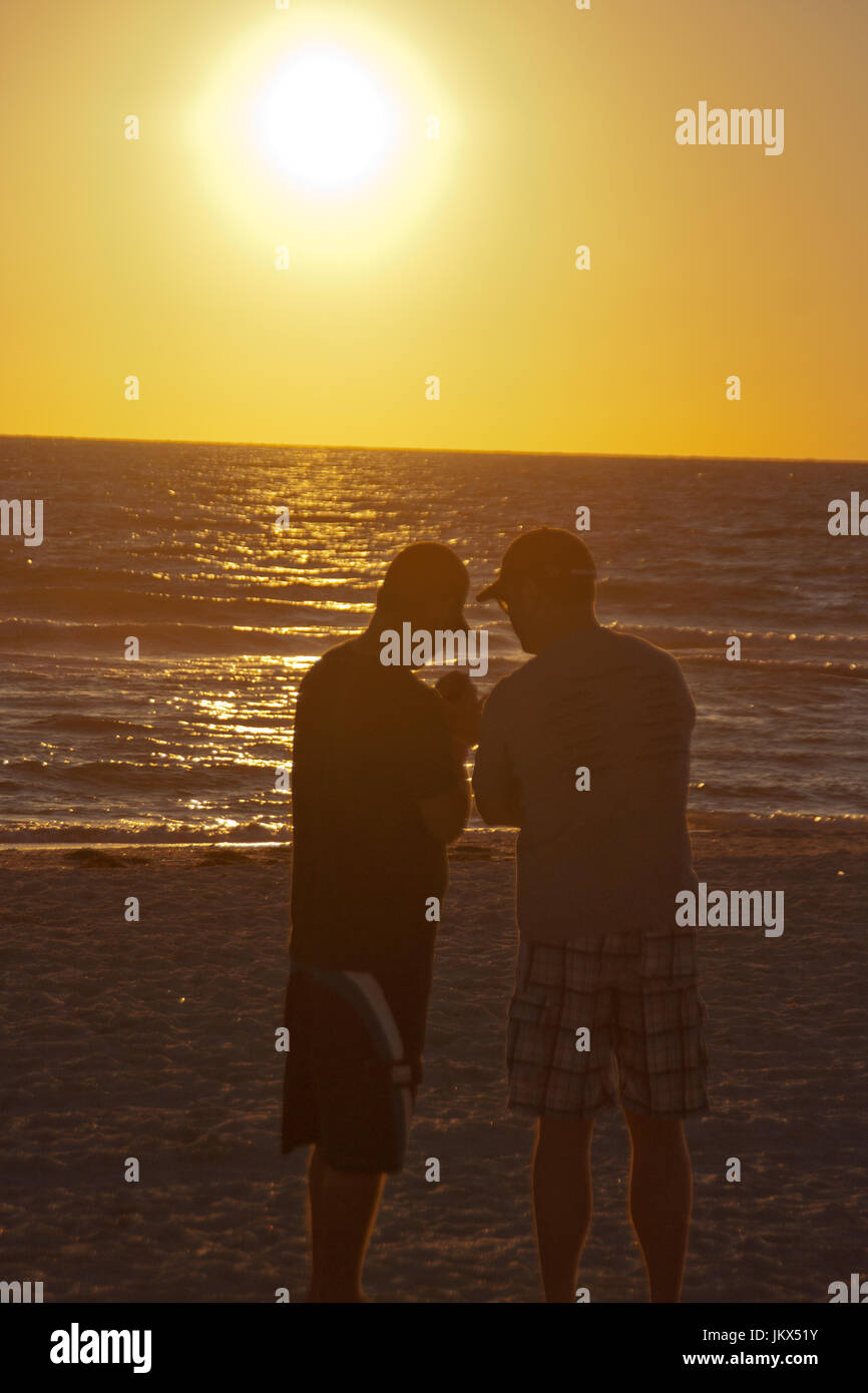 Friends talking at sunset Stock Photo - Alamy