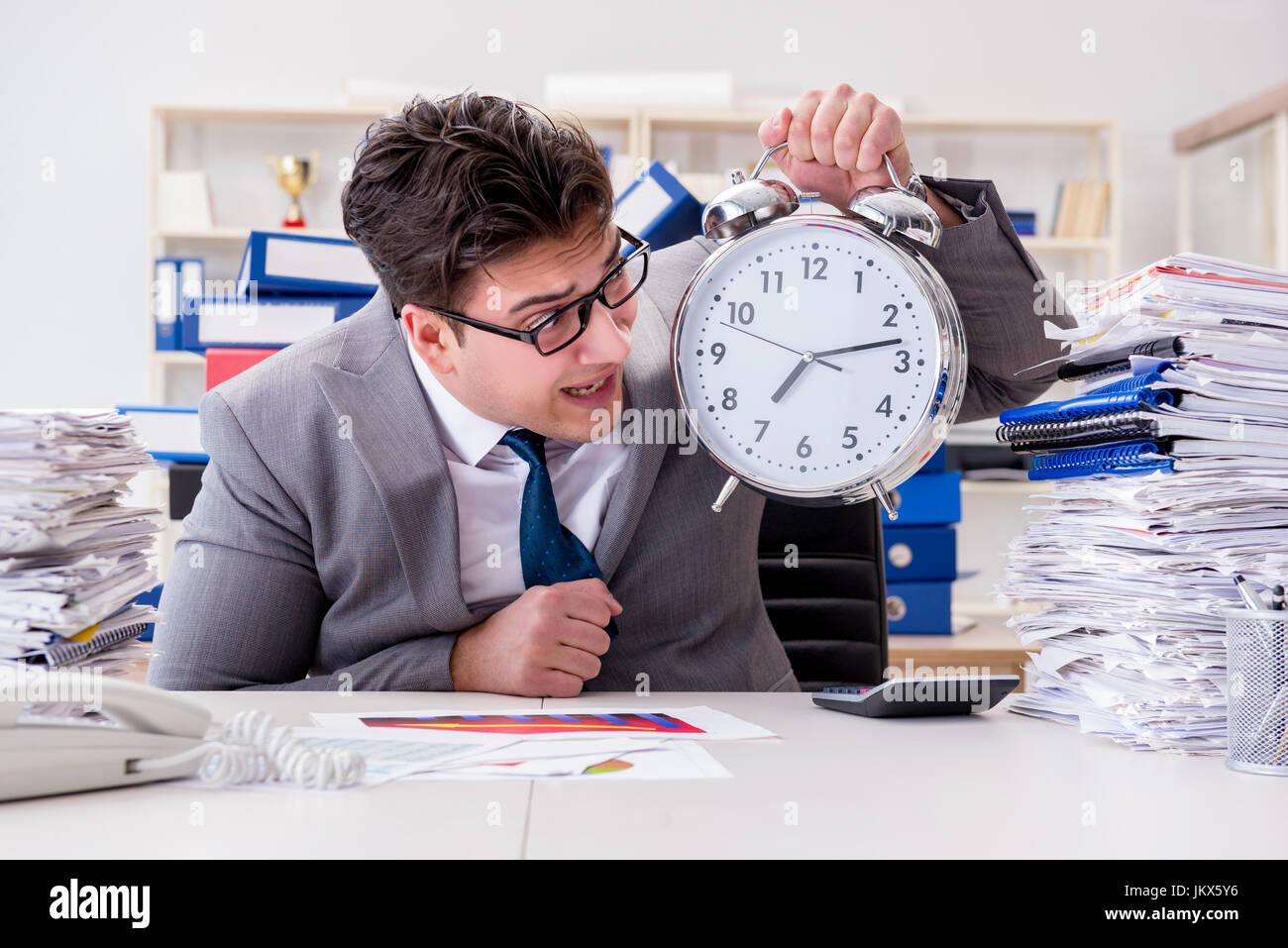 Businessman missing deadlines due to excessive work Stock Photo - Alamy