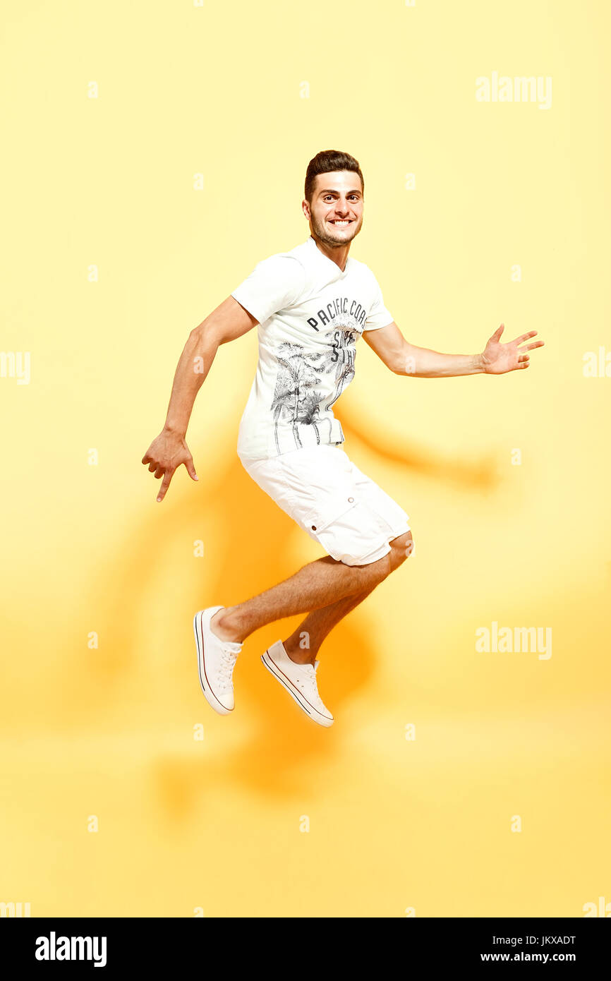 Handsome guy jumping looking at camera Stock Photo - Alamy