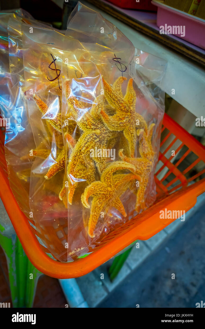 Dry sea stars inside of a plastic bags, in an orange baskets, in a ...