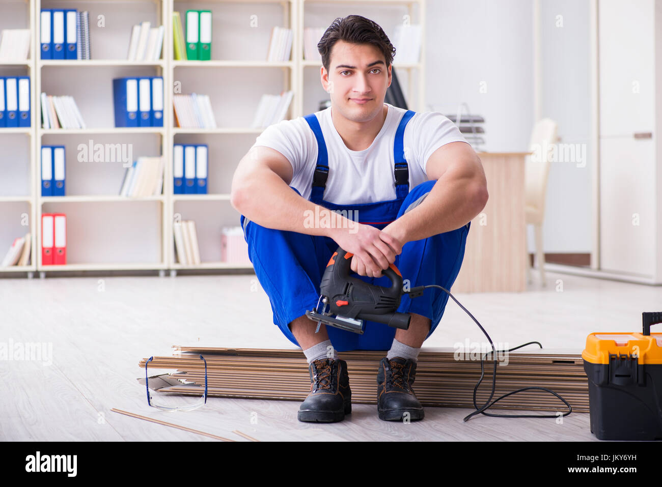 Young worker working on floor laminate tiles Stock Photo - Alamy