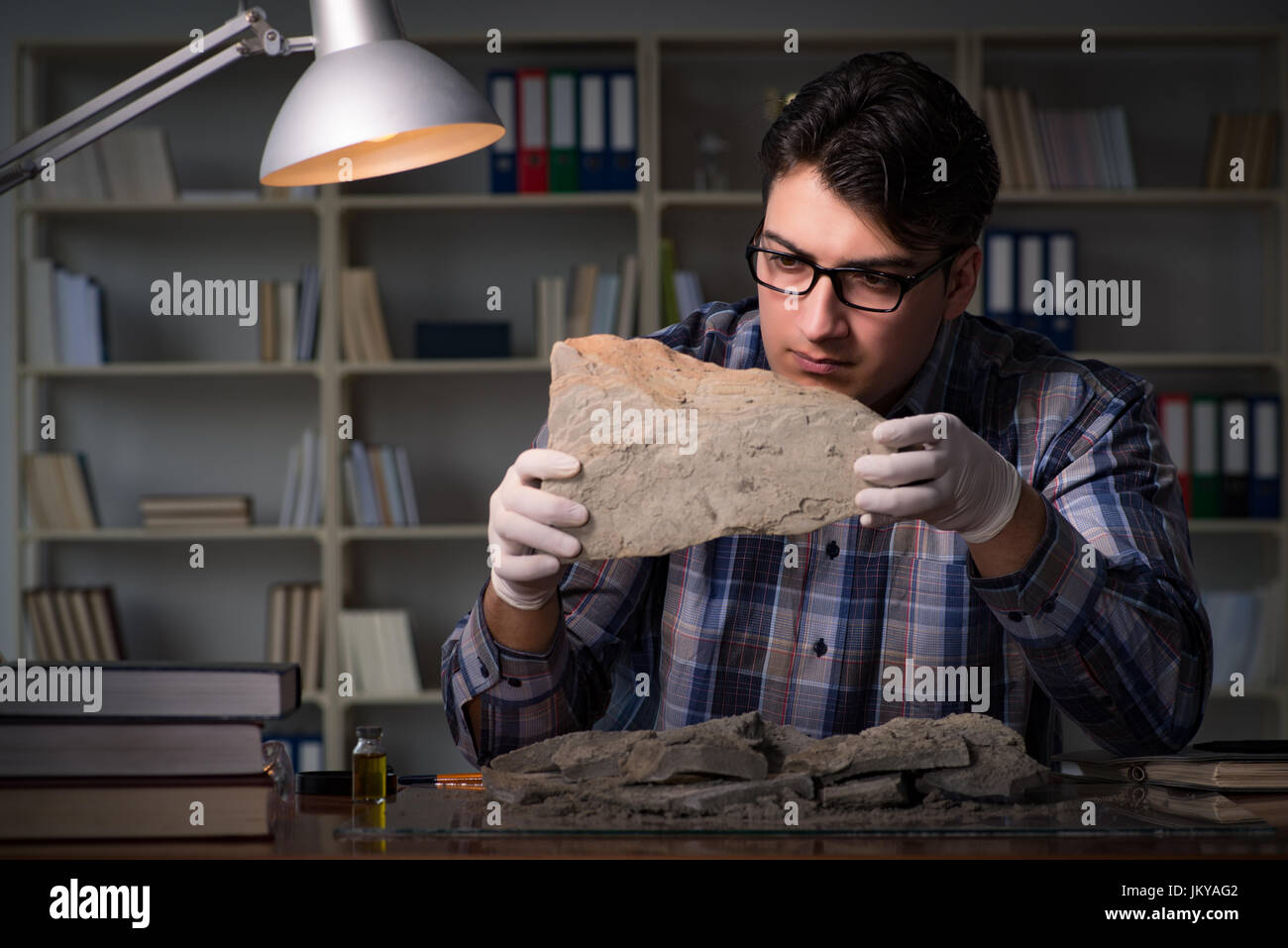 Archeologist working late night in office Stock Photo - Alamy