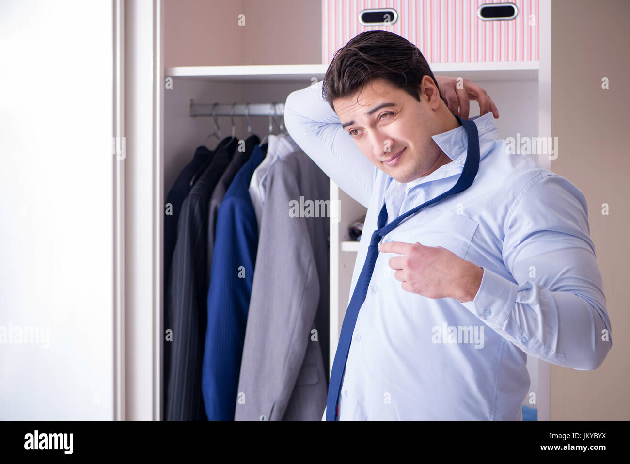 Young man businessman getting dressed for work Stock Photo - Alamy