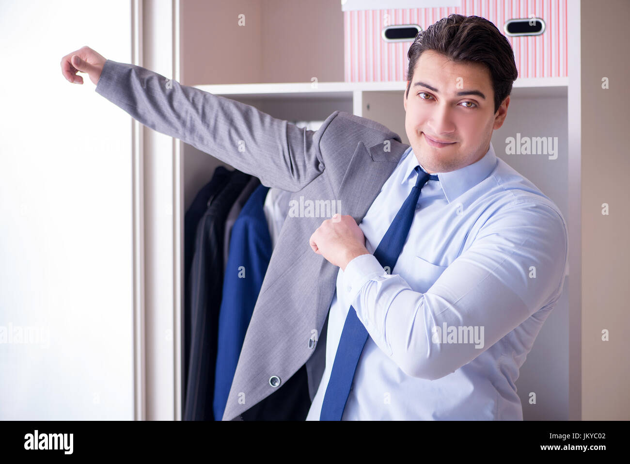 Young man businessman getting dressed for work Stock Photo - Alamy