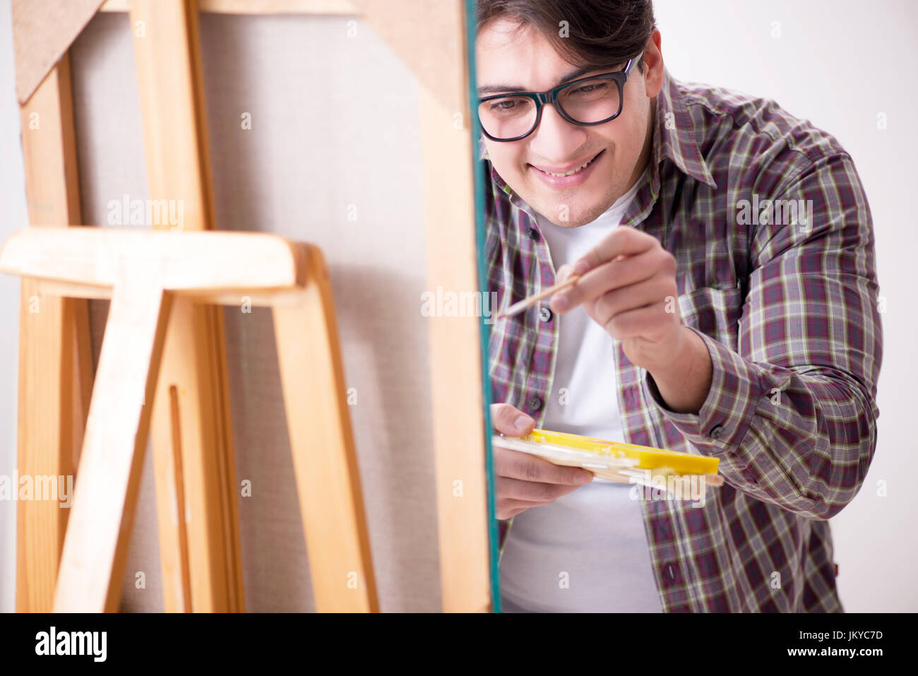 Young male artist drawing pictures in bright studio Stock Photo - Alamy