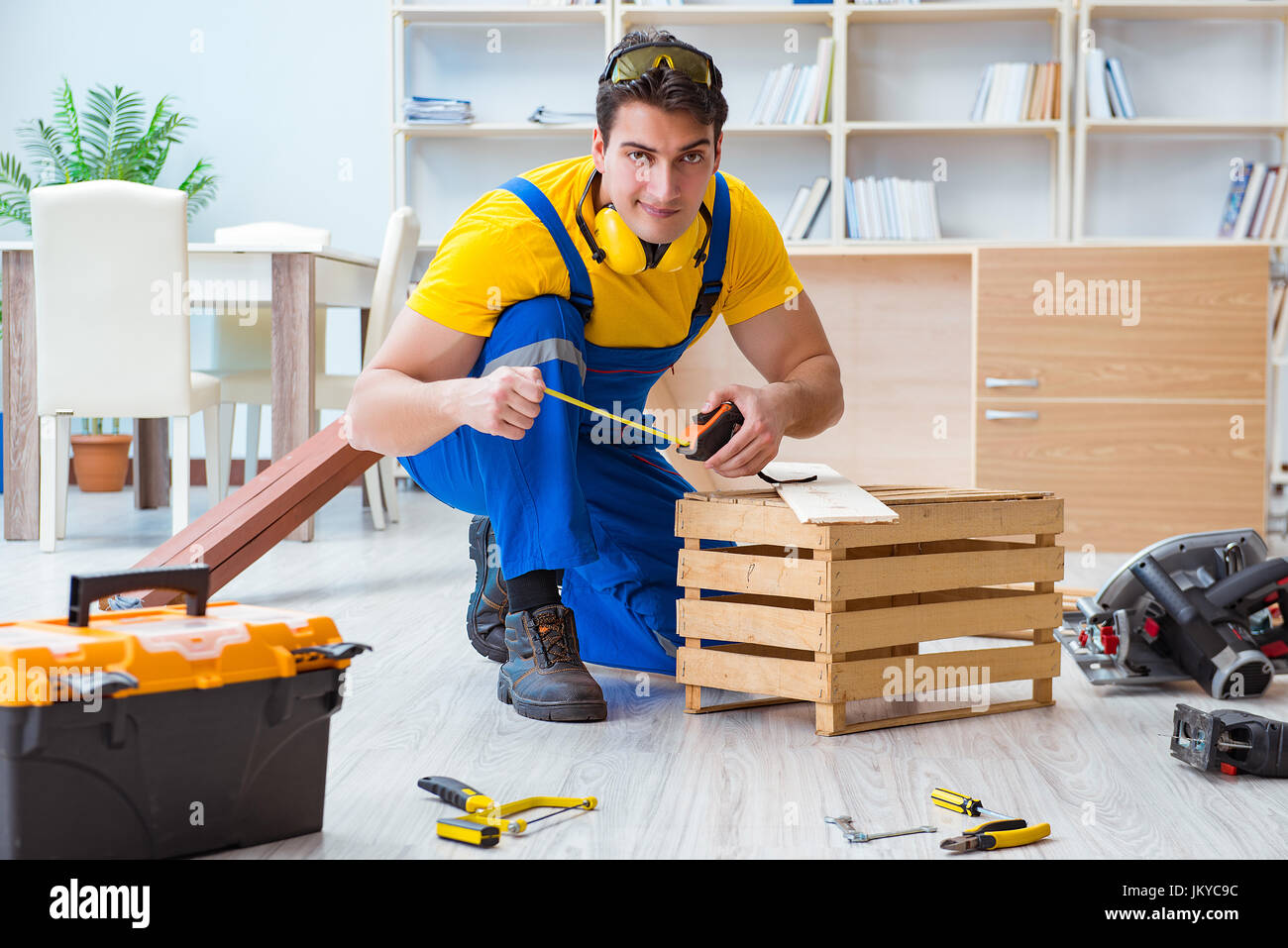 Repairman carpenter working with wooden board plank and measuring tape ...