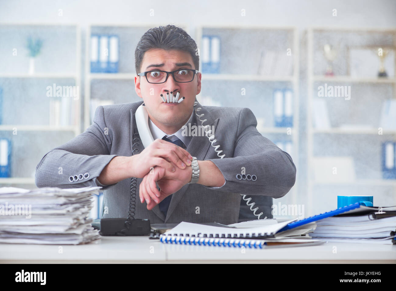 Businessman smoking in office at work Stock Photo - Alamy