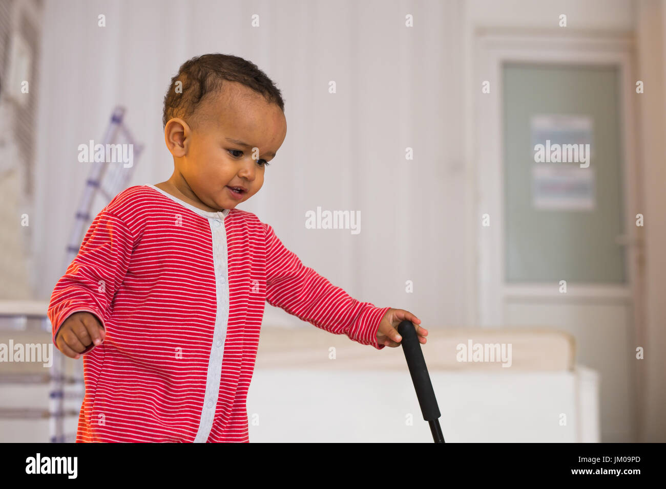 Cute curious baby study things in the room Stock Photo - Alamy