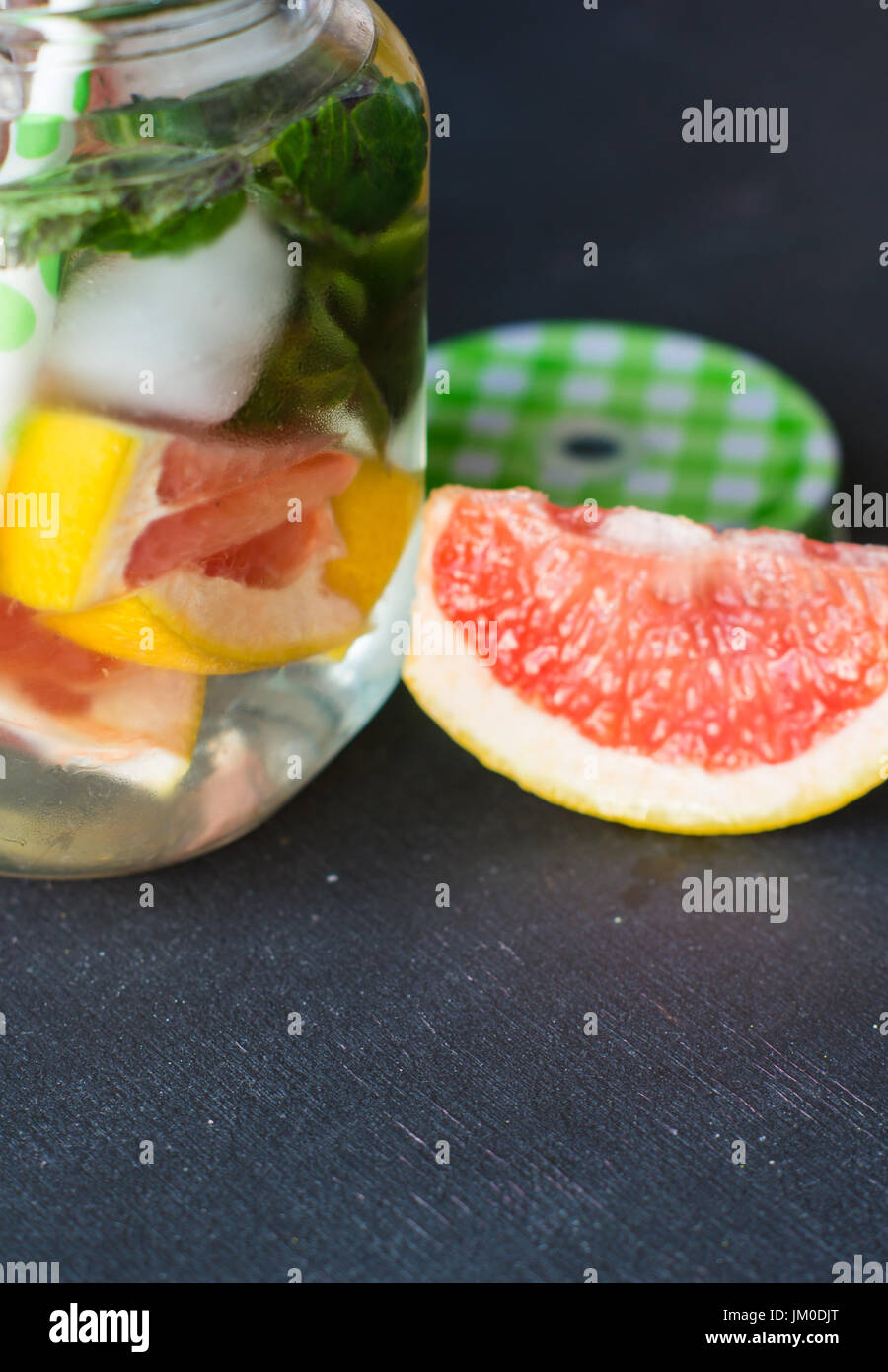 Organic detox drink with ice mint, grapefruit in the bottle with straw ...