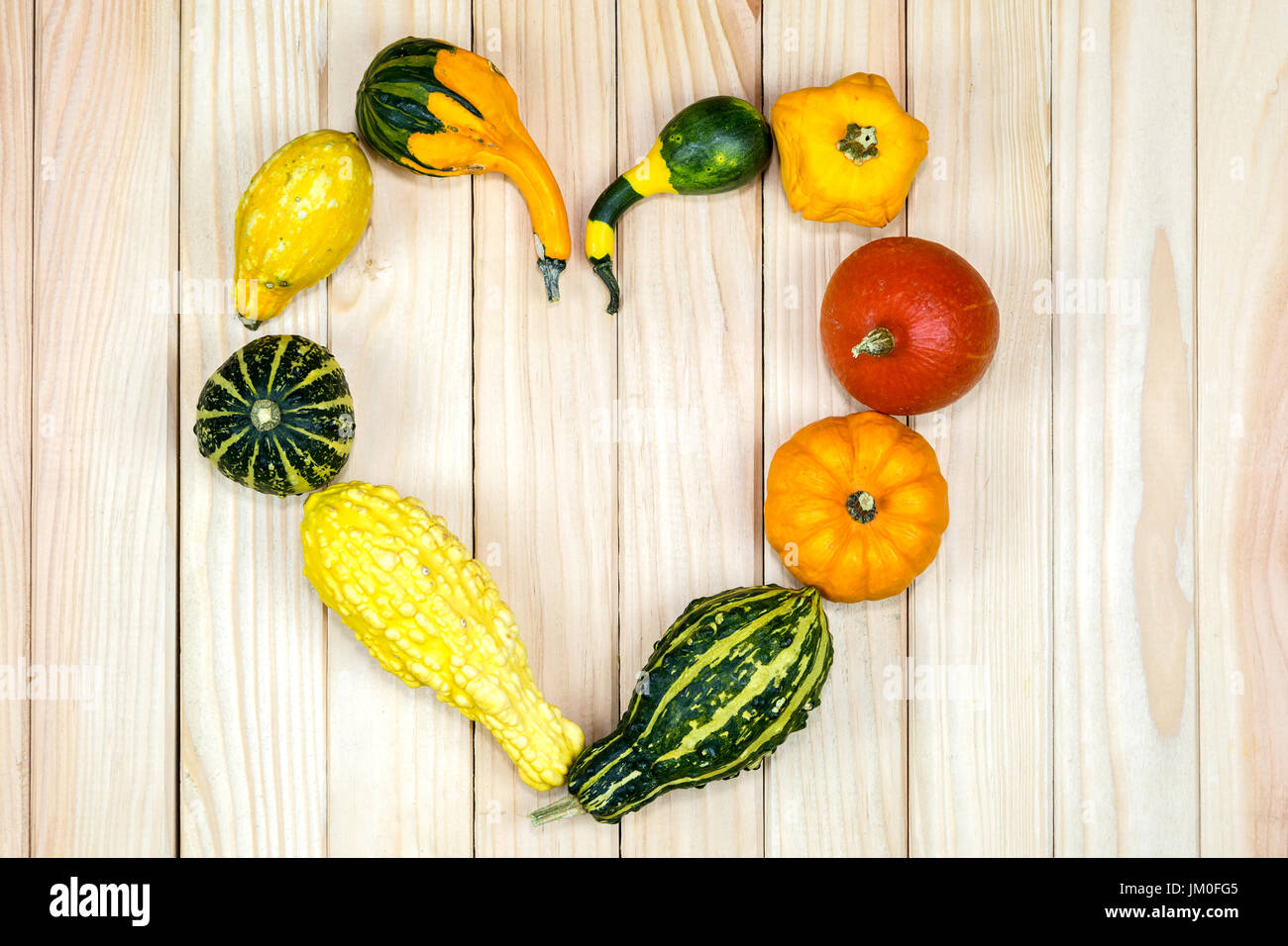 Many different pumpkins lie in heart shape on wood Stock Photo - Alamy