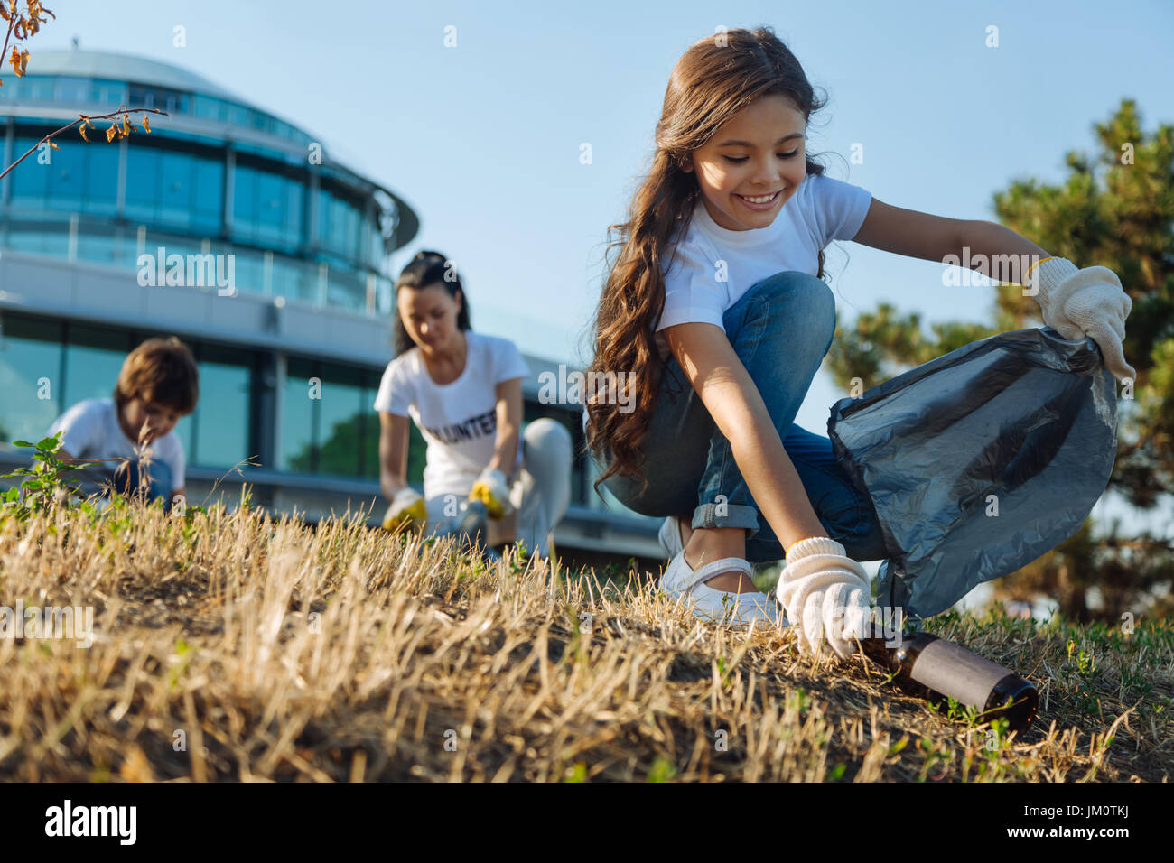 Delighted little girl working in volunteer group Stock Photo - Alamy