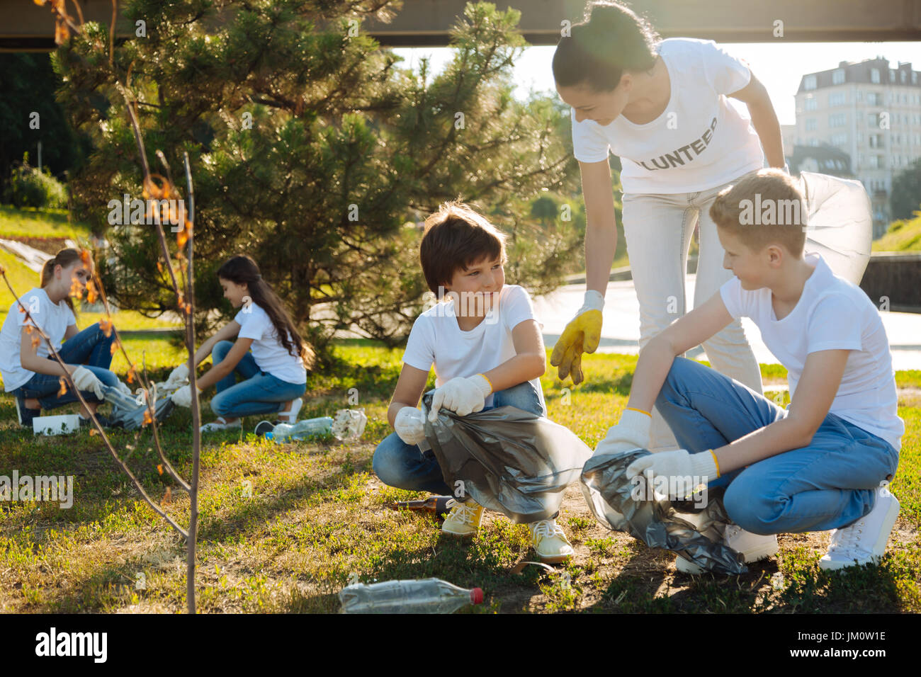 Cheerful girls gathering glass bottles Stock Photo - Alamy