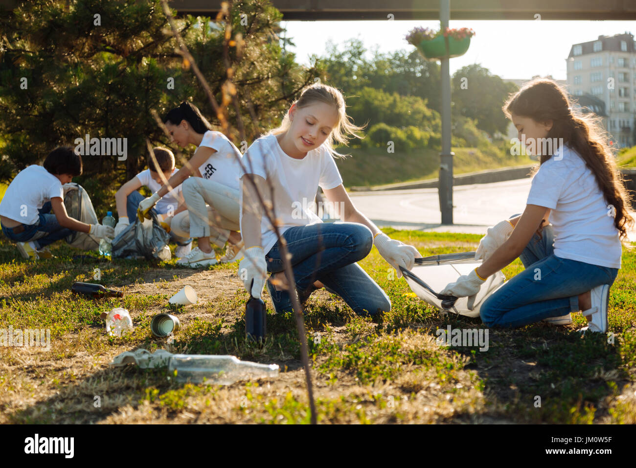 Little children cleaning grass from rubbish Stock Photo - Alamy