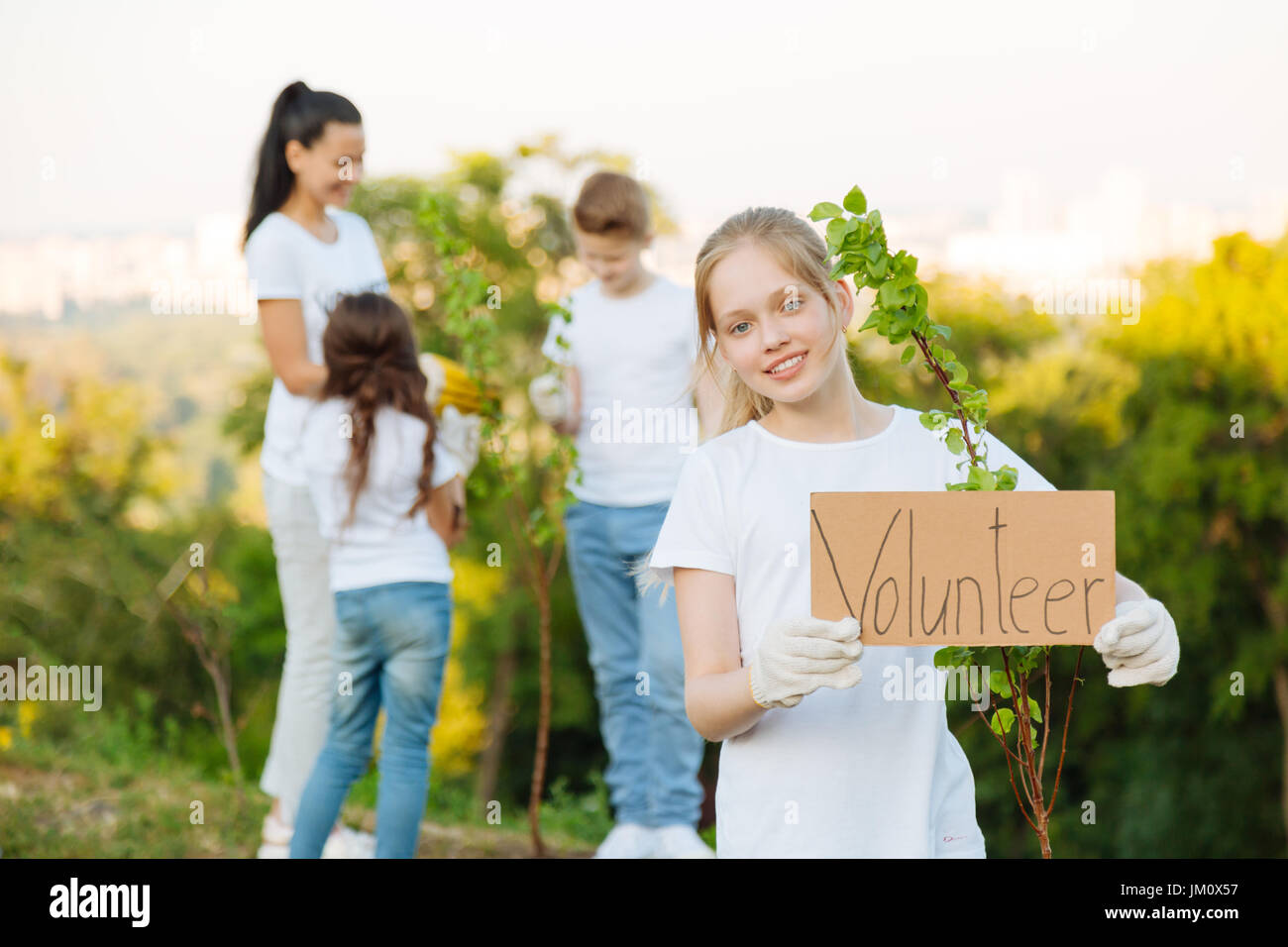 Positive girl demonstrating her tree Stock Photo - Alamy