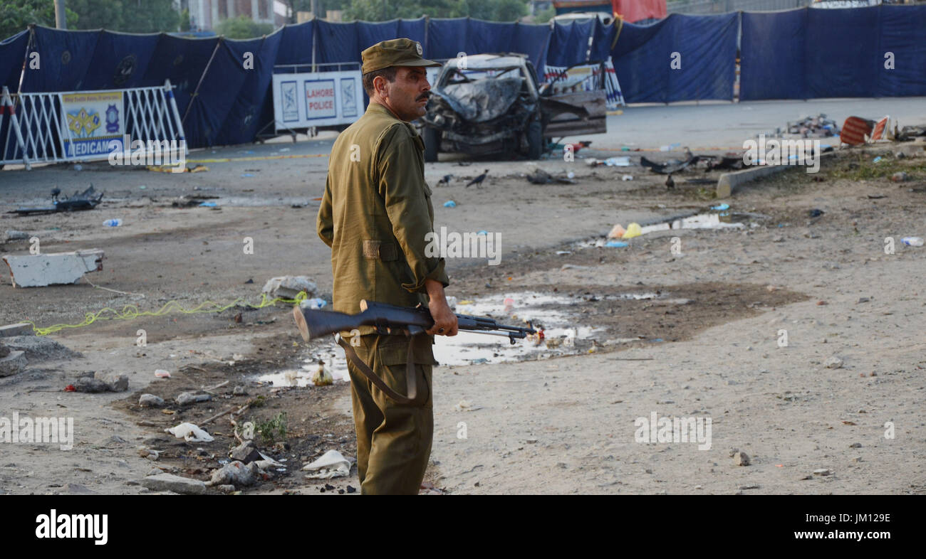 Pakistani security officials cordon off the scene of a suicide bomb ...
