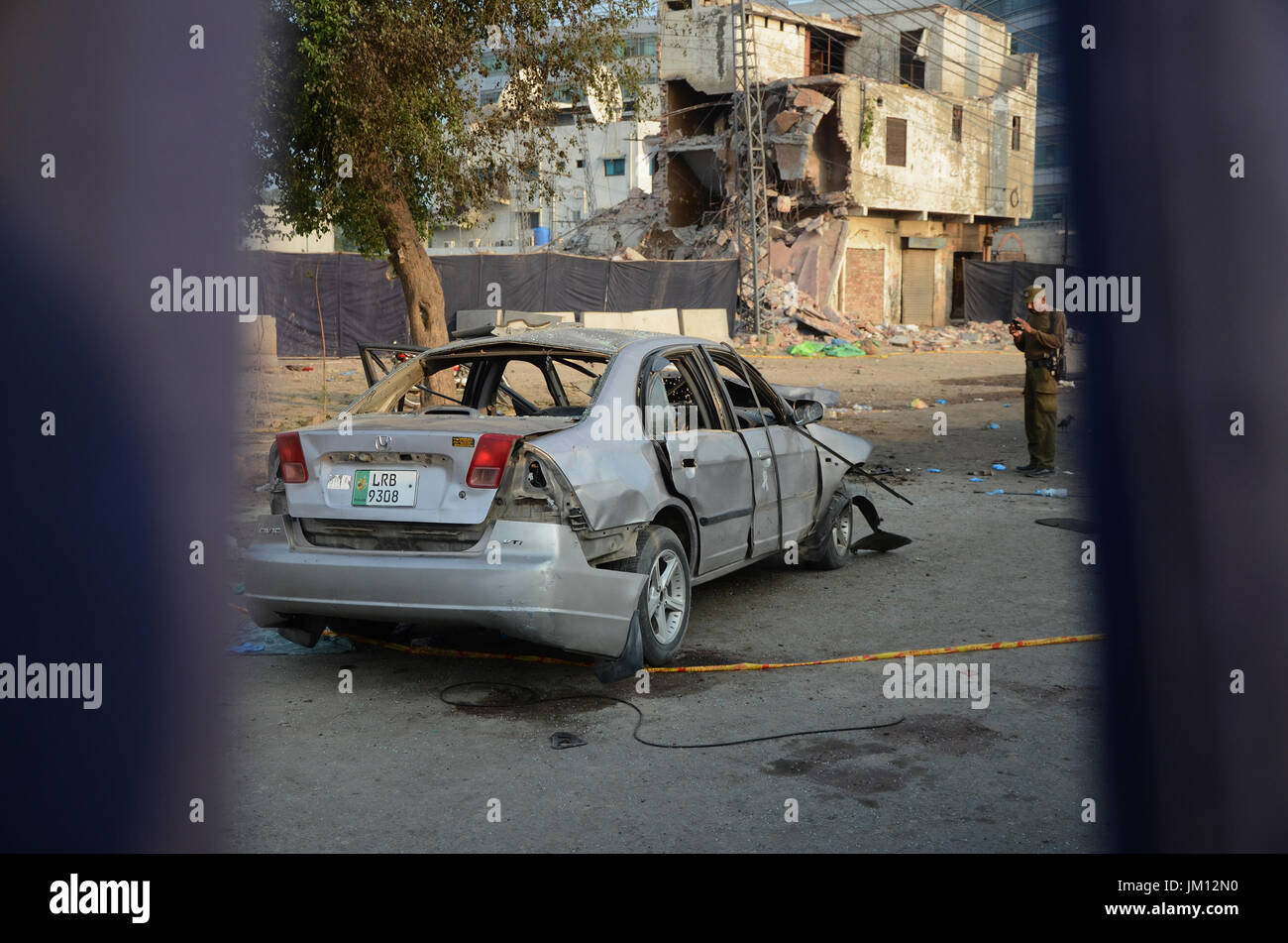 Pakistani security officials cordon off the scene of a suicide bomb ...