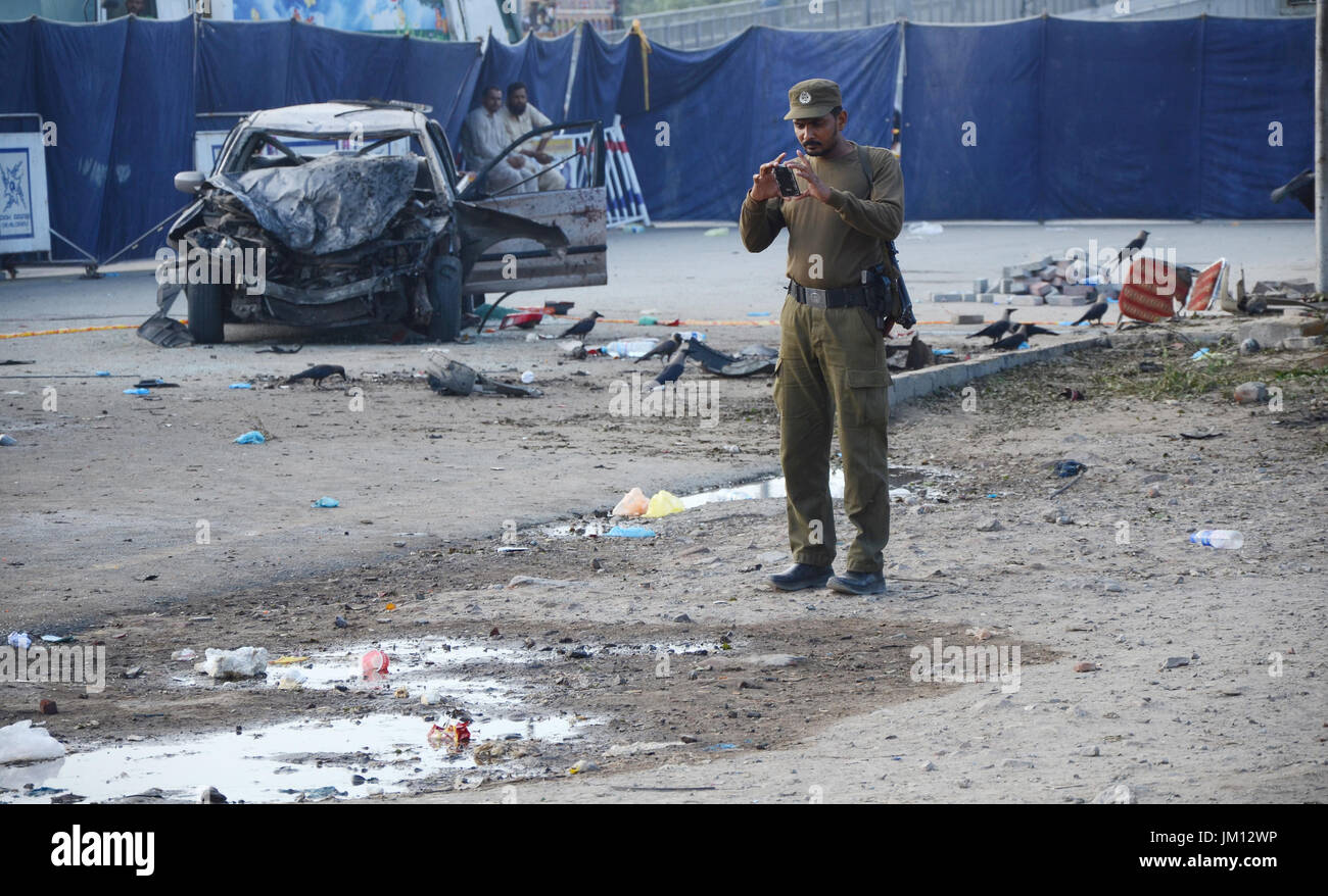Pakistani security officials cordon off the scene of a suicide bomb ...