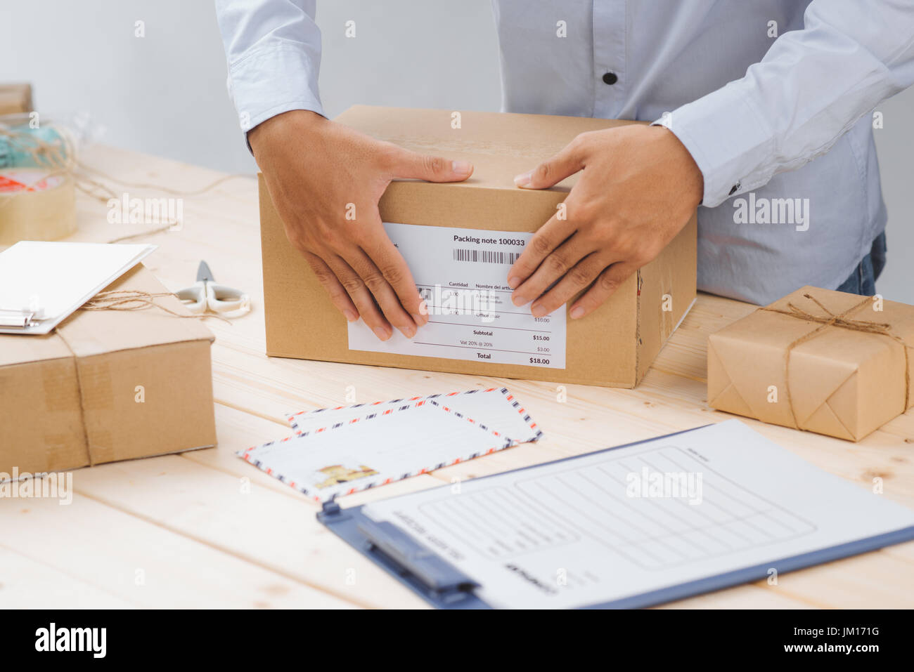 Deliveryman taping and packing cardboard box for delivery Stock Photo ...