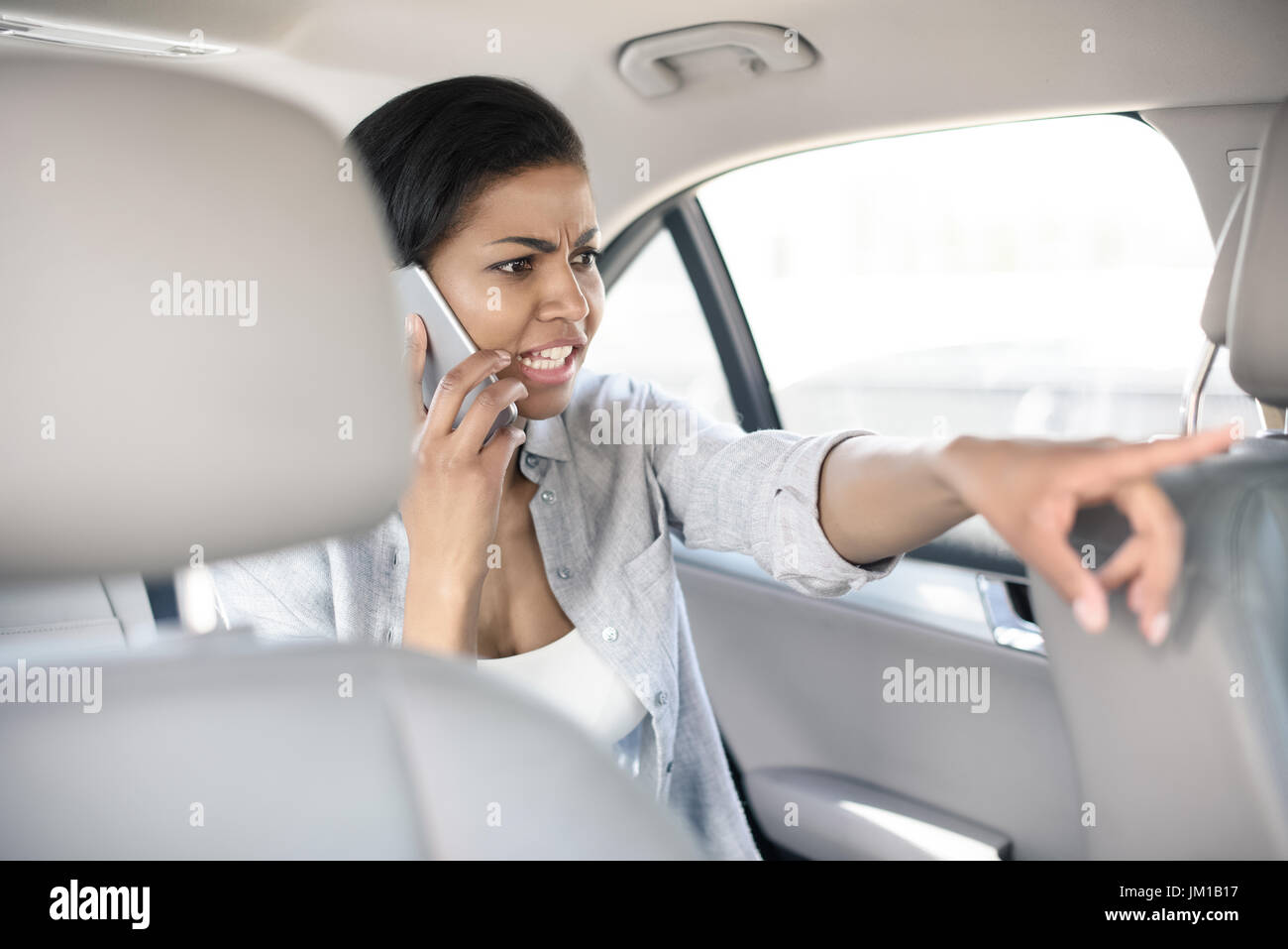 angry african american woman using smartphone in taxi Stock Photo - Alamy